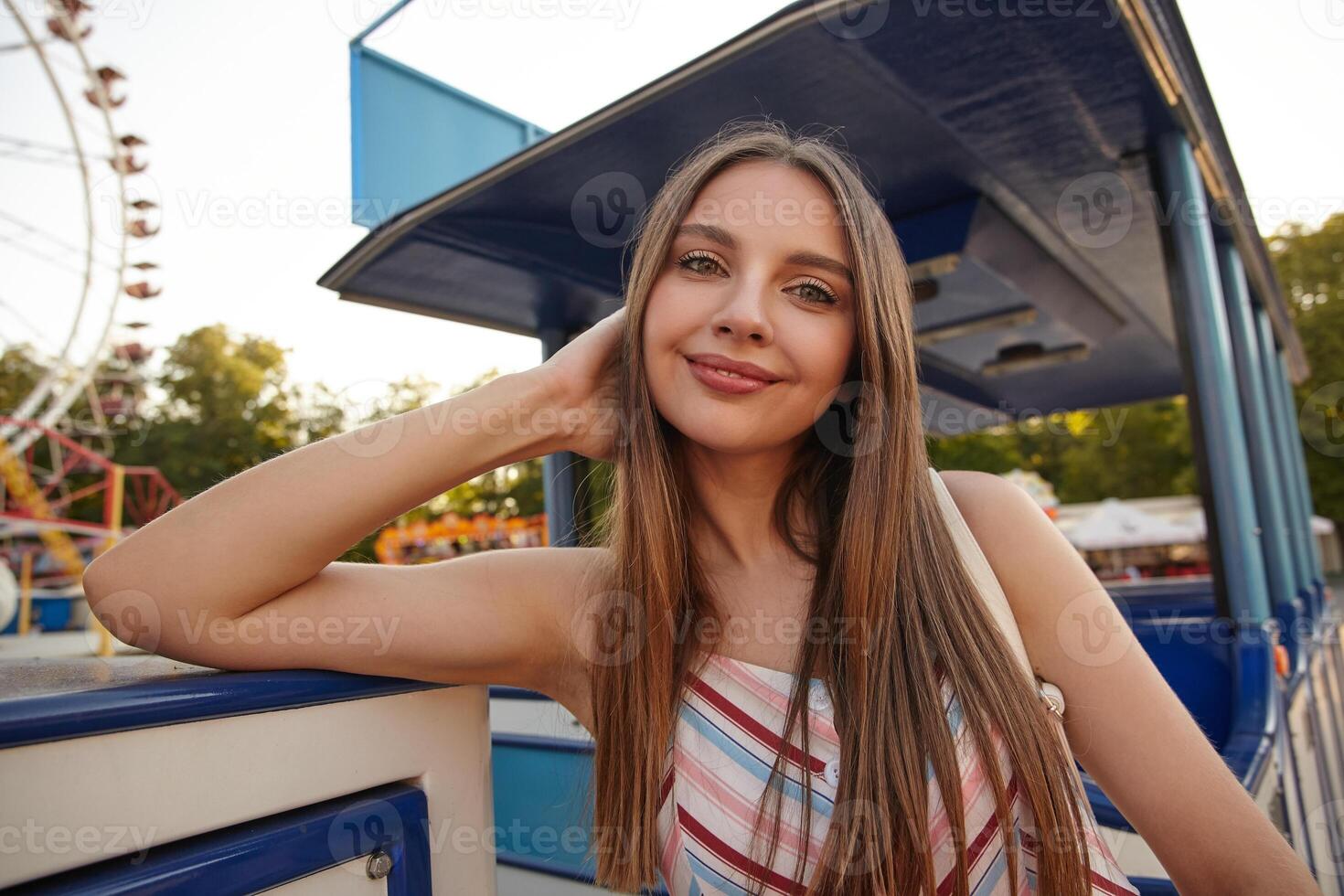Outdoor close-up of attractive young female with brown long hair ...
