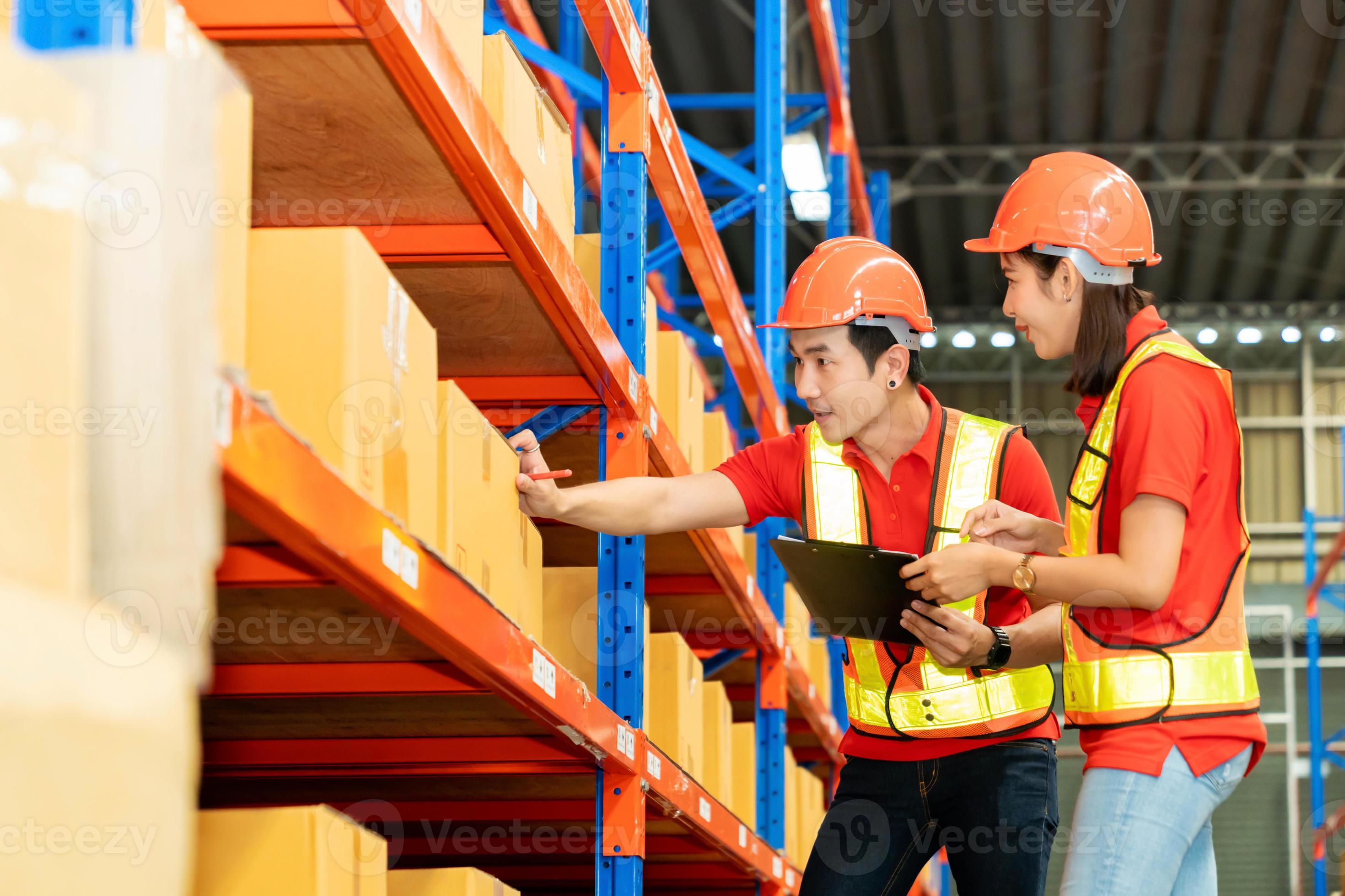 Man worker hold clipboard document talking to woman in warehouse store. Male and female ...