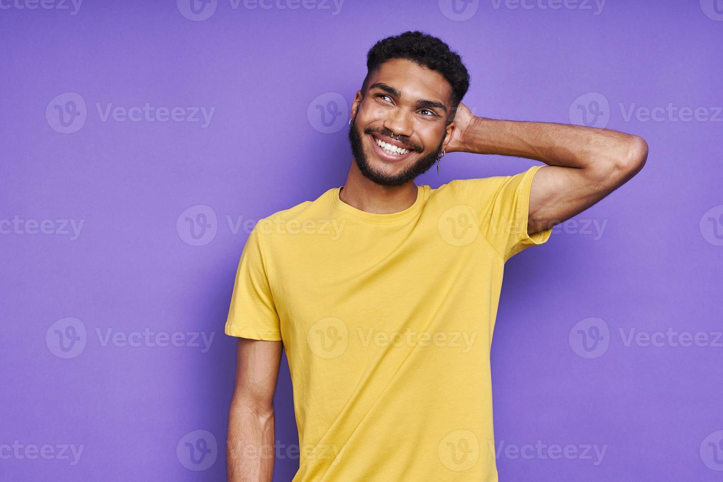 Thoughtful African man holding hand behind head while standing against ...