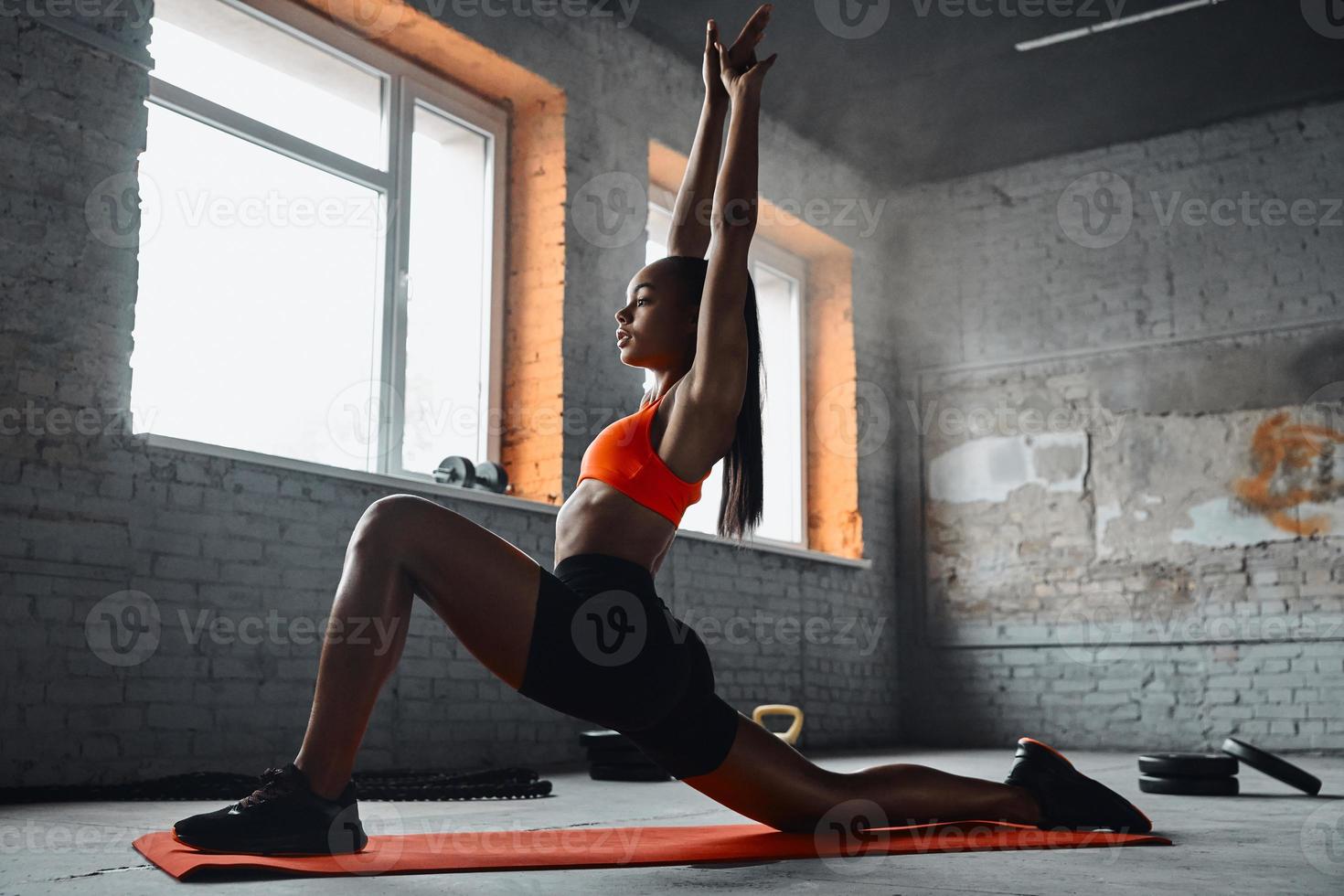 Confident young African woman doing stretching exercises in gym ... Confident young African woman doing stretching exercises in gym ...