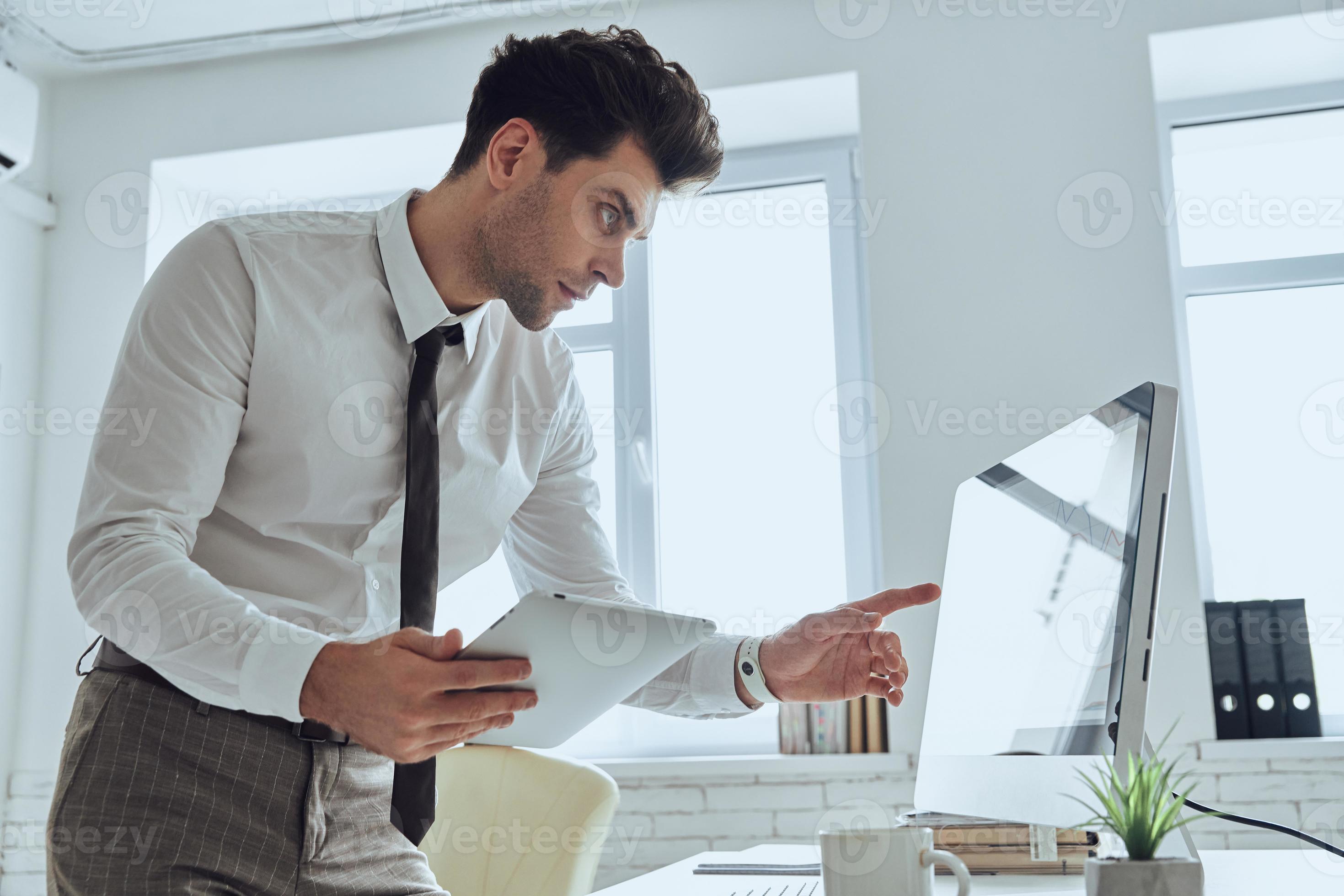 Handsome Young Man In Shirt And Tie Using Technologies While Working In