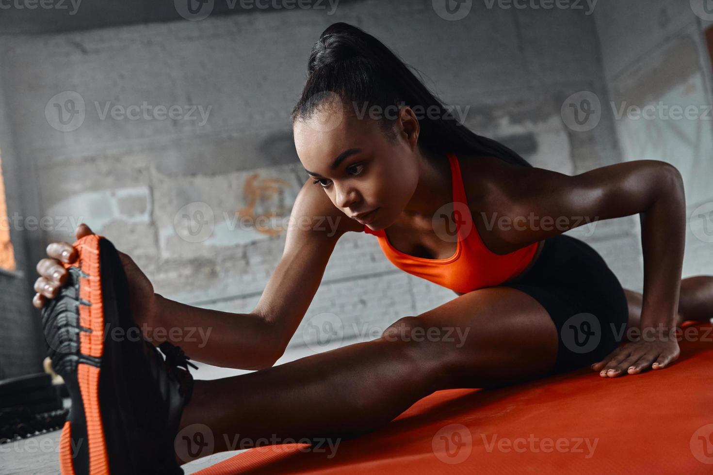 Confident young African woman stretching on splits in gym 10177335 ... Confident young African woman stretching on splits in gym 10177335 ...