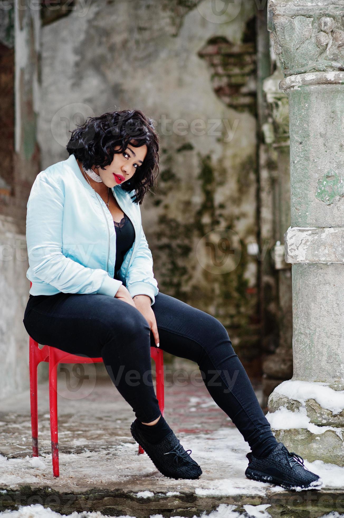 Stylish African American Plus Size Model Sitting On Red Chair Outdoor