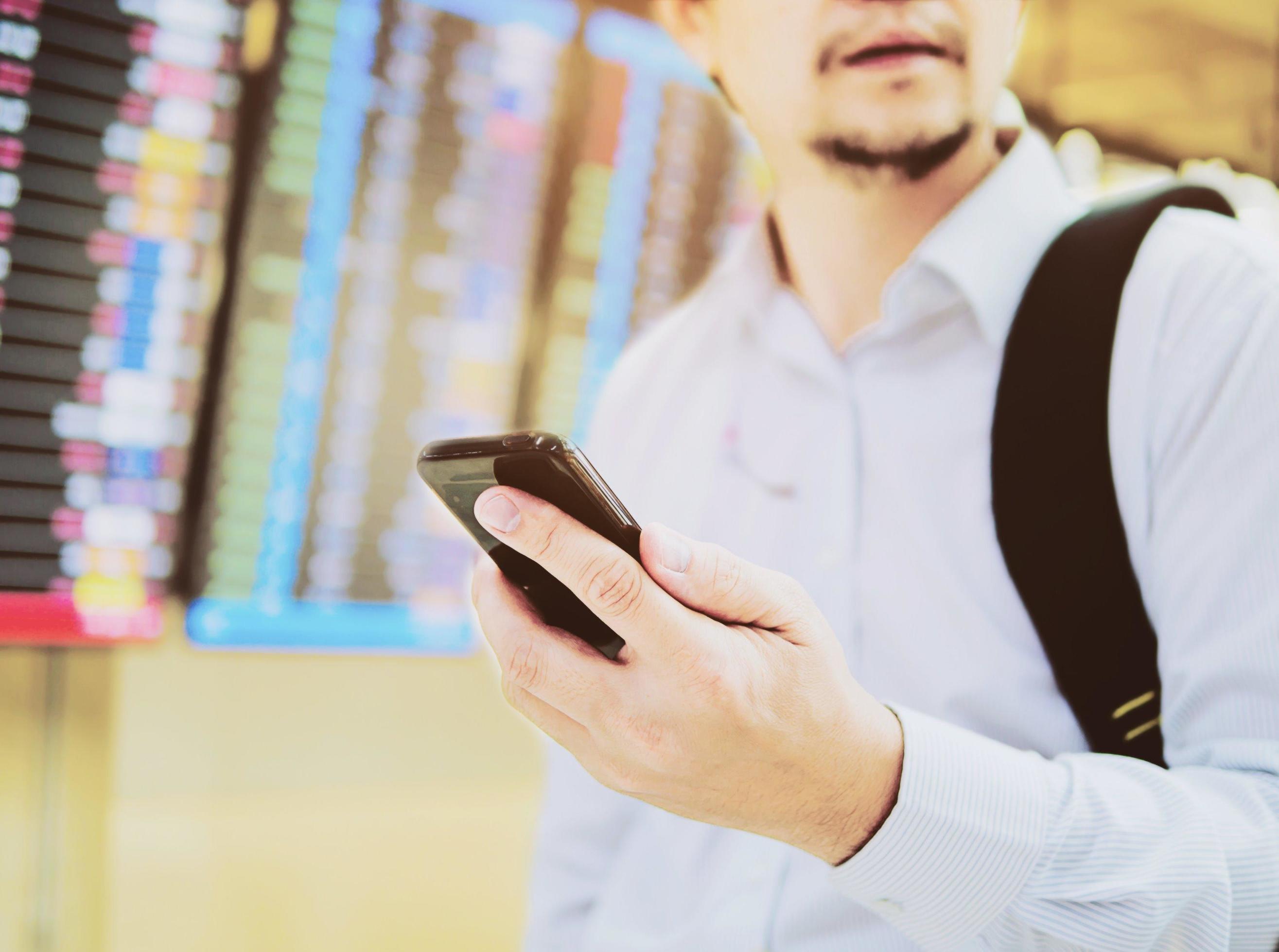 Business traveler using mobile phone during his journey at airport ...