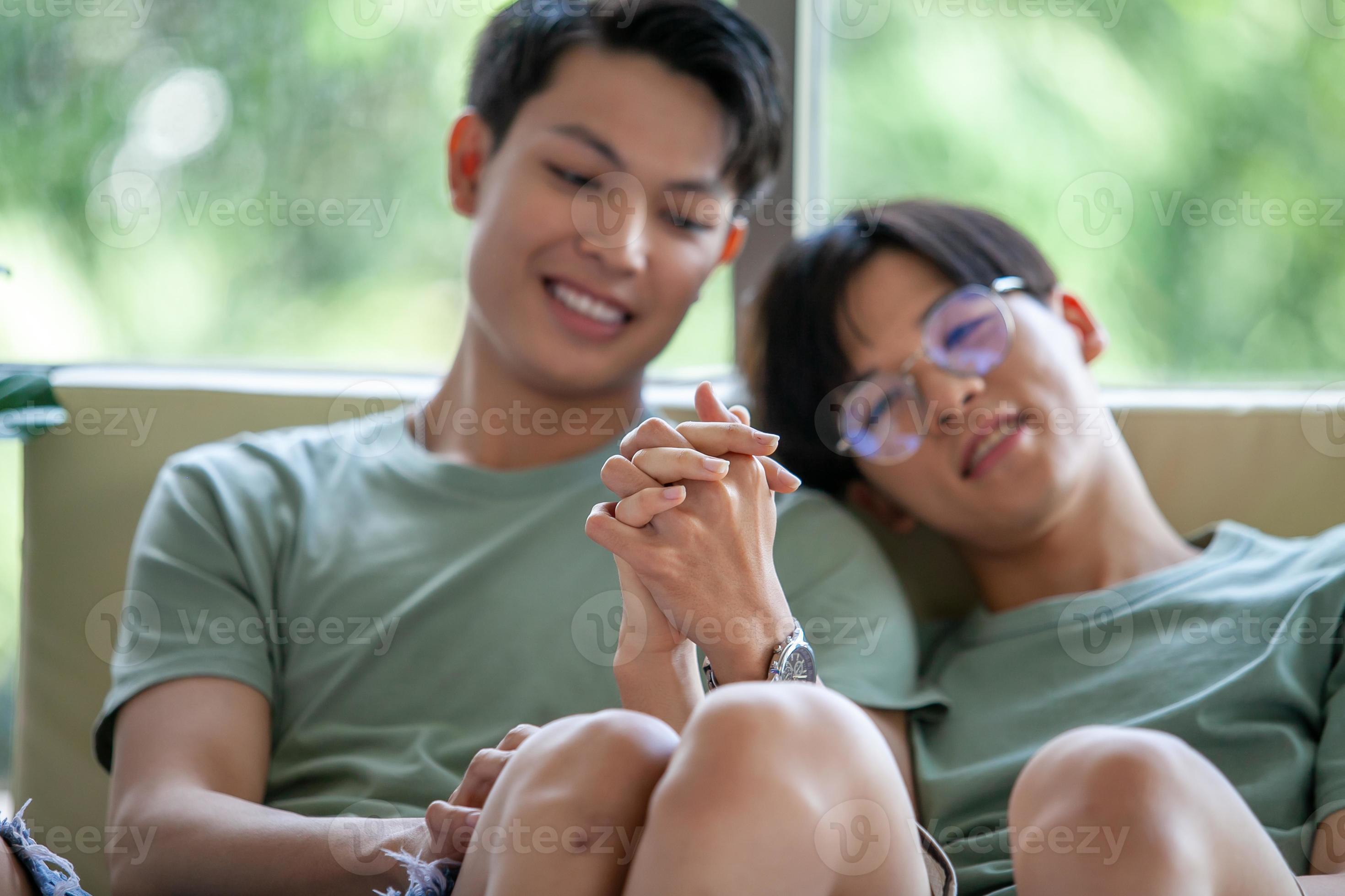 Happy Asian Gay Couple Holding Hands Together Relaxing At Home On Sofa