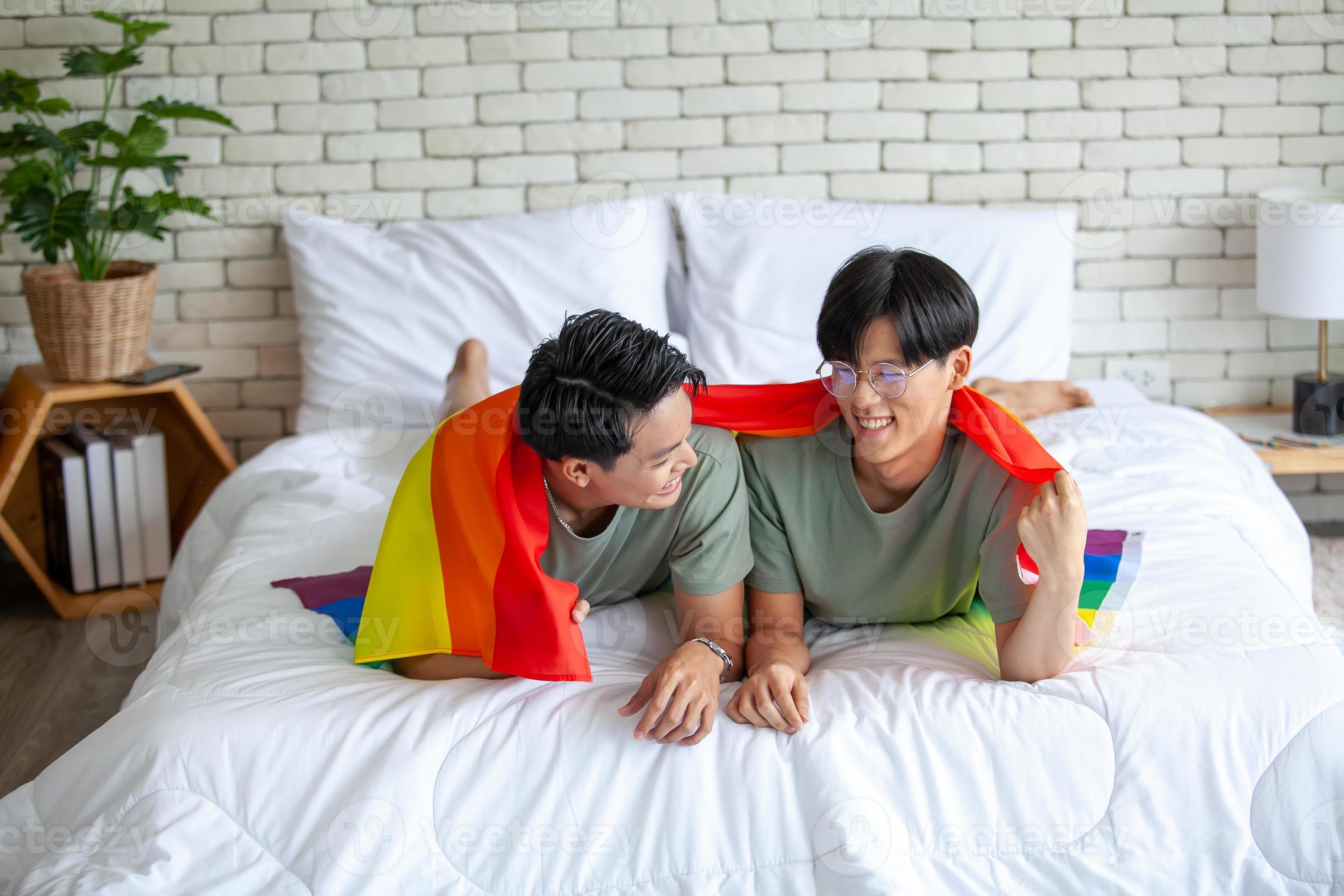 Happy Asian Gay Couple Talking Together And Relaxing At Home On Bed