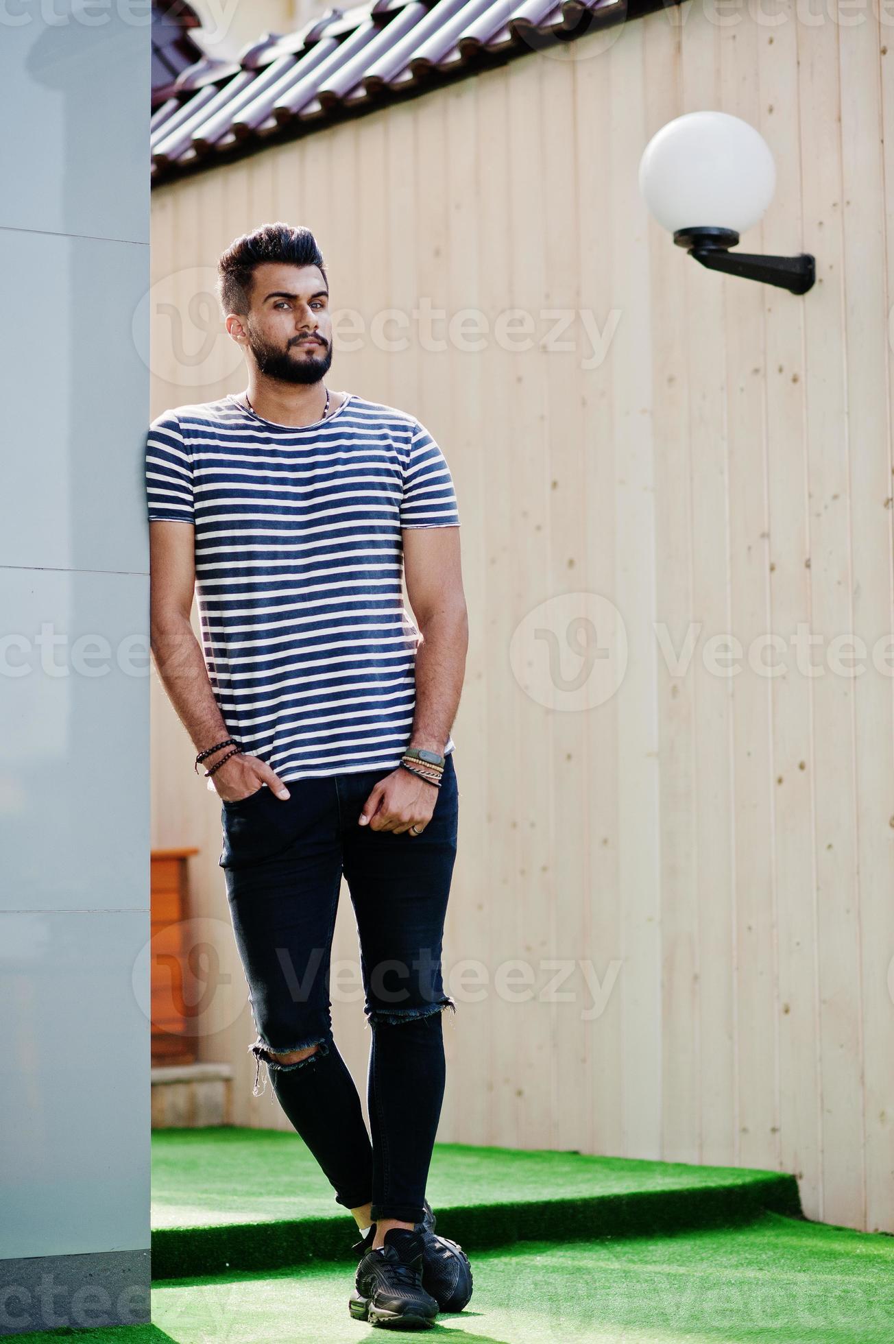 Handsome tall arabian beard man model at stripped shirt posed outdoor ...
