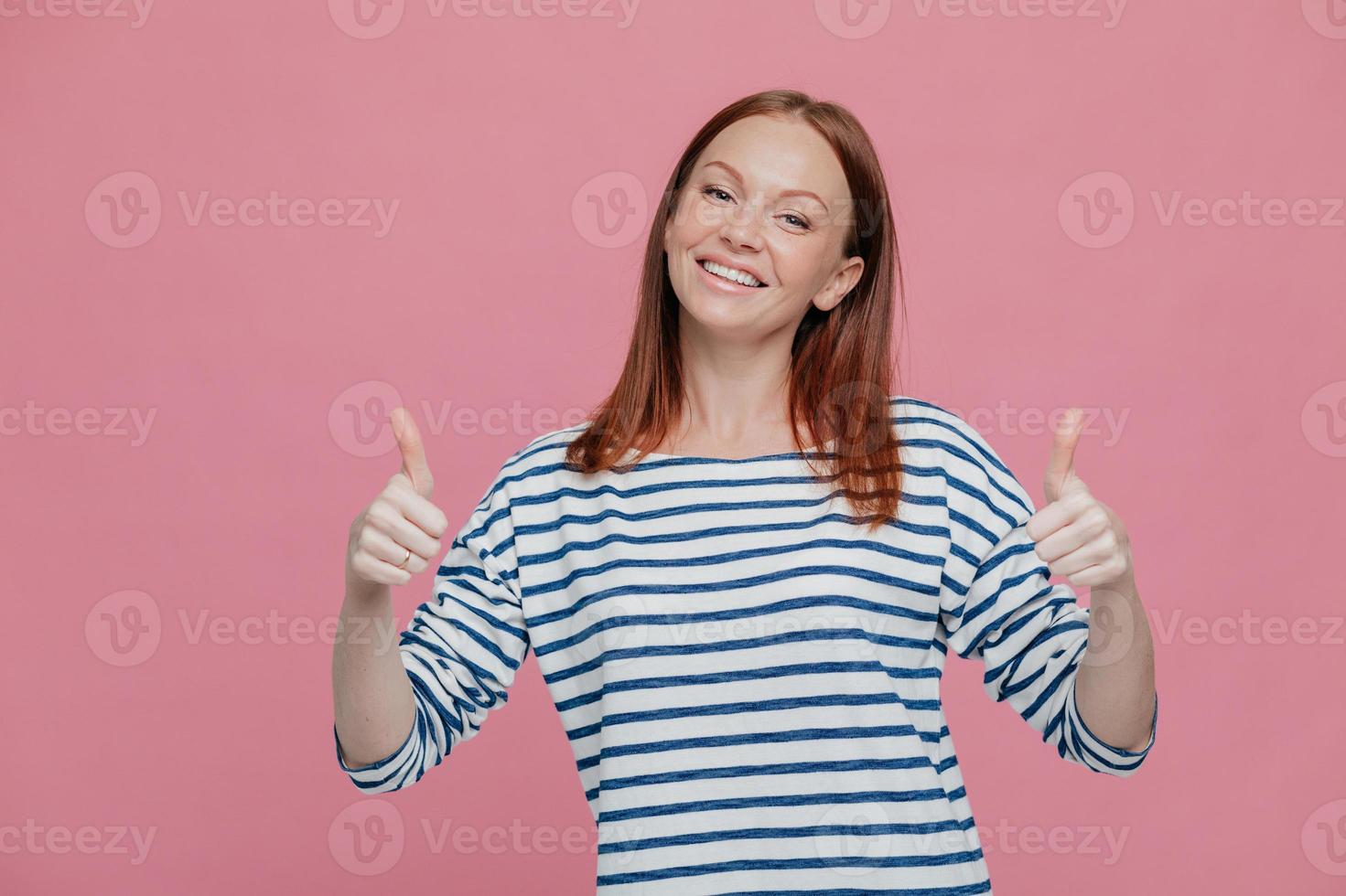 Waist Up Shot Of Pretty Pleased Young Woman Wears Striped Jumper