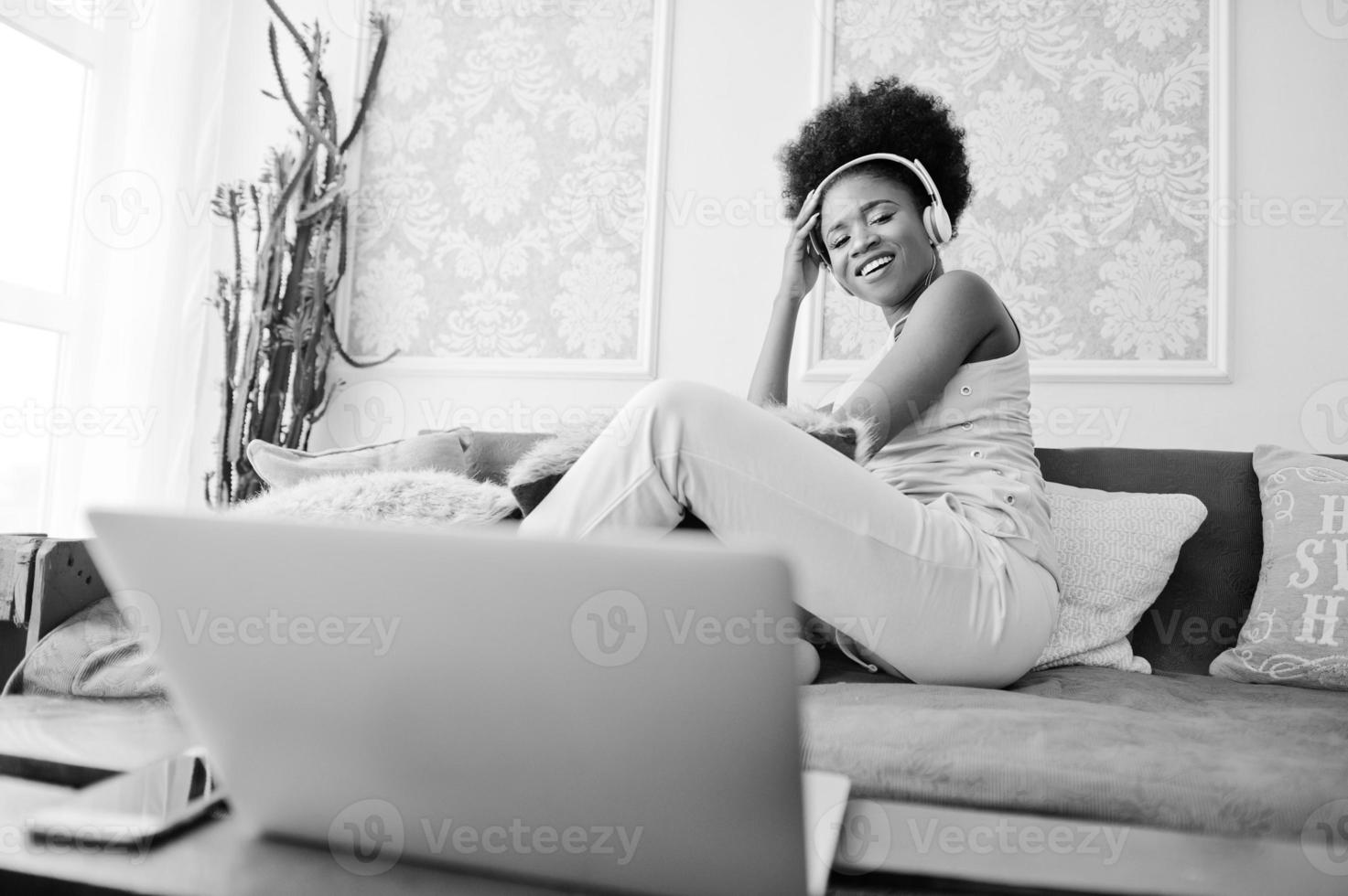 Young African American Woman Sitting On The Couch While Working On