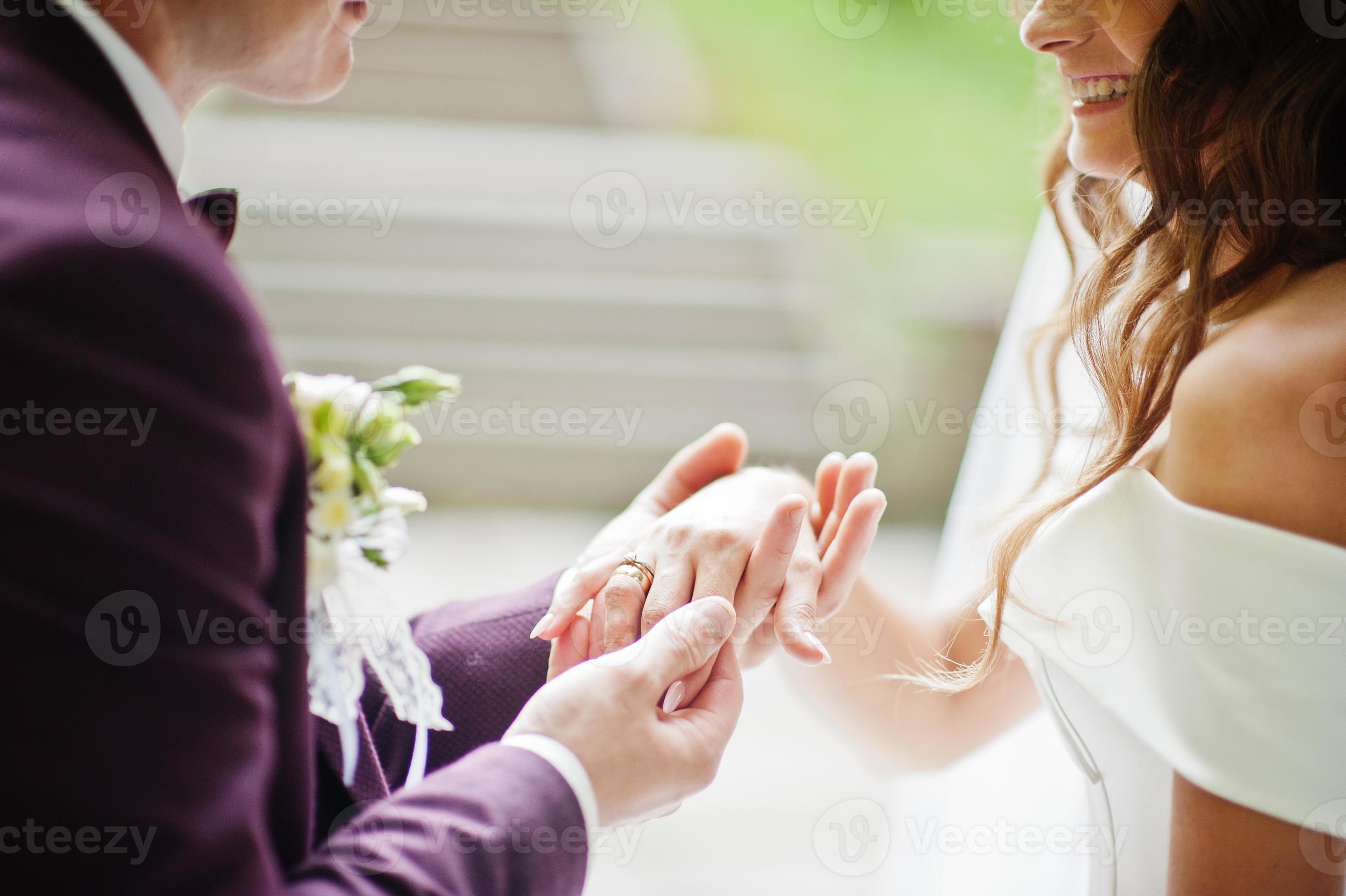 Bride and groom holding hands, close up. Their happy wedding day ...
