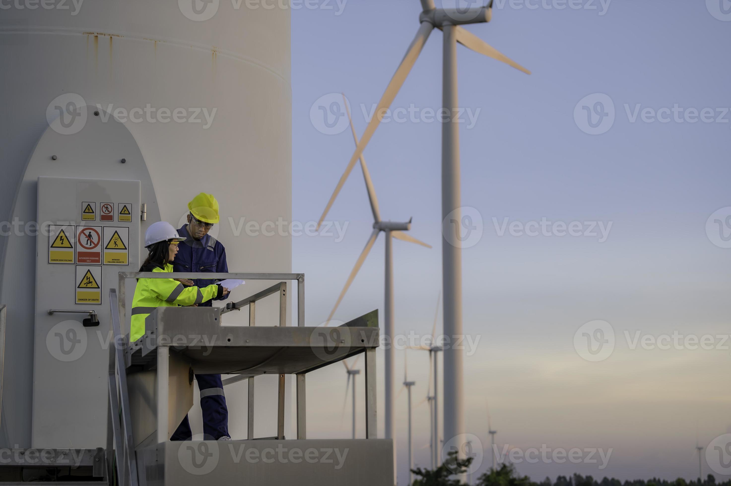 Two Engineers Working And Holding The Report At Wind Turbine Farm Power