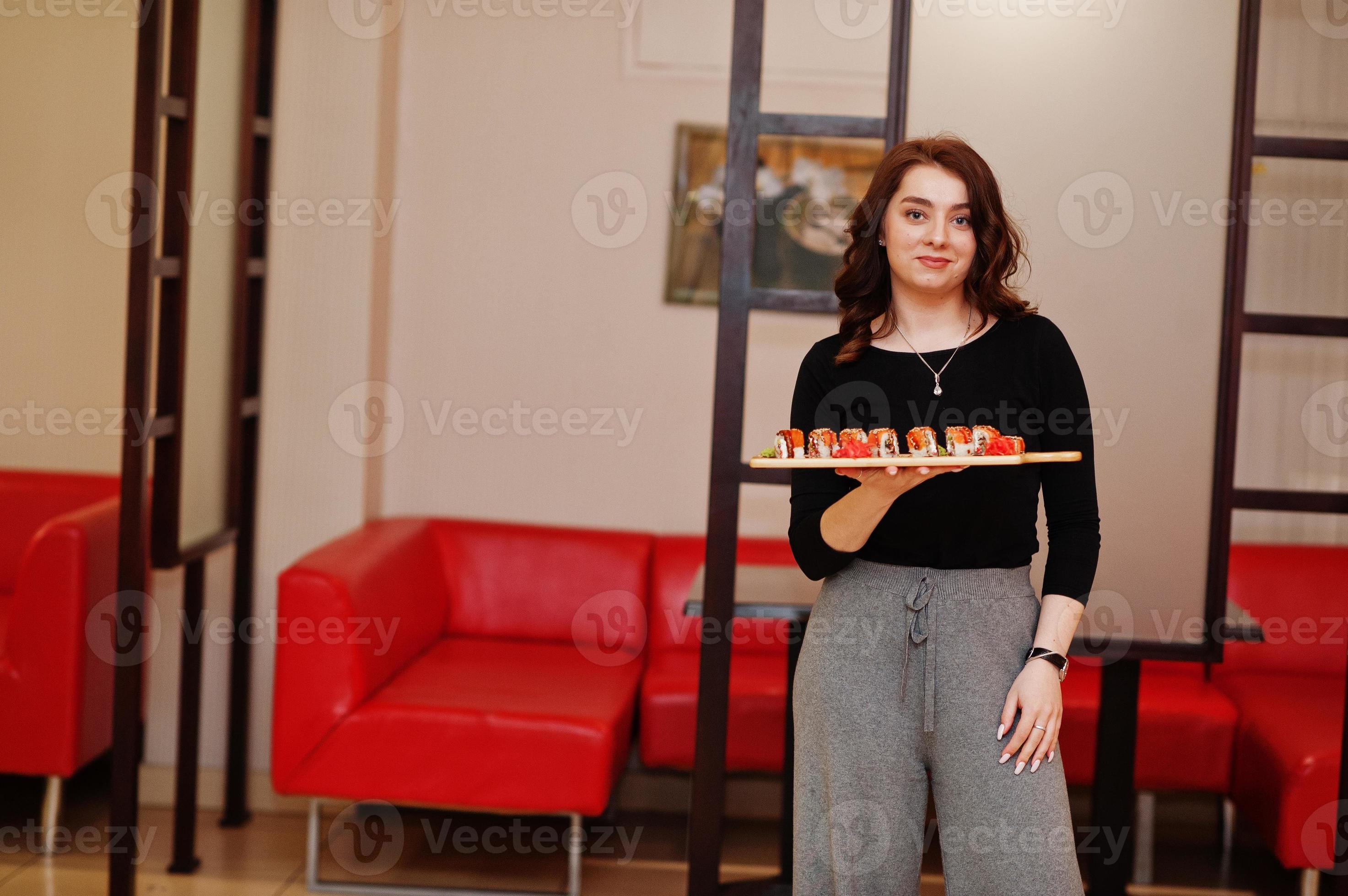 A Young Beautiful Girl Eating Sushi On Traditional Japanese Restaurant