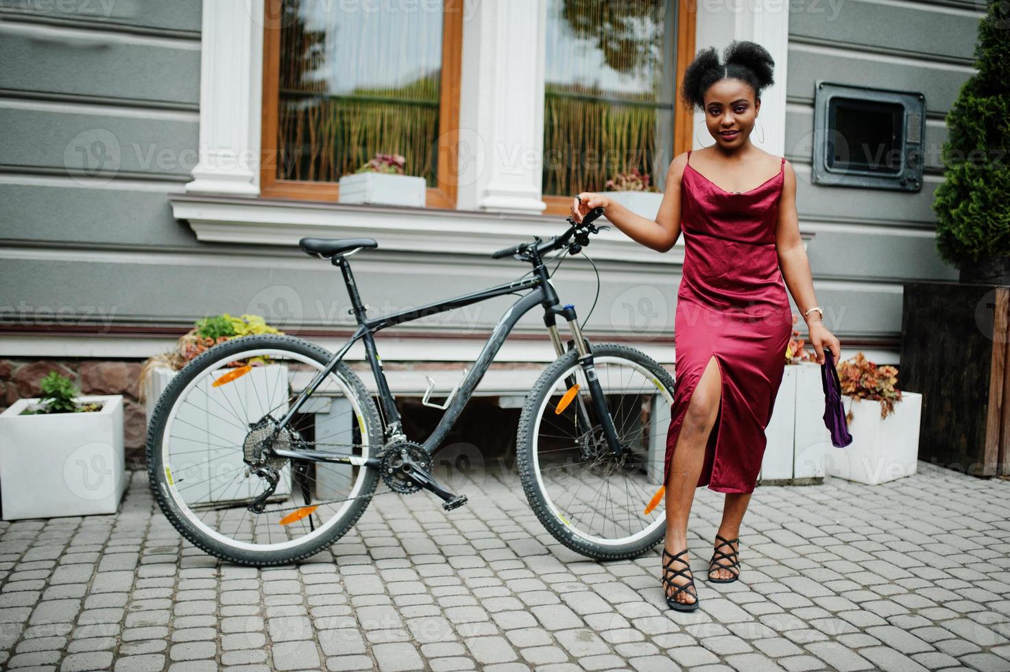 Portrait of a beautiful natural young African woman with afro hair. Black model in red silk ...