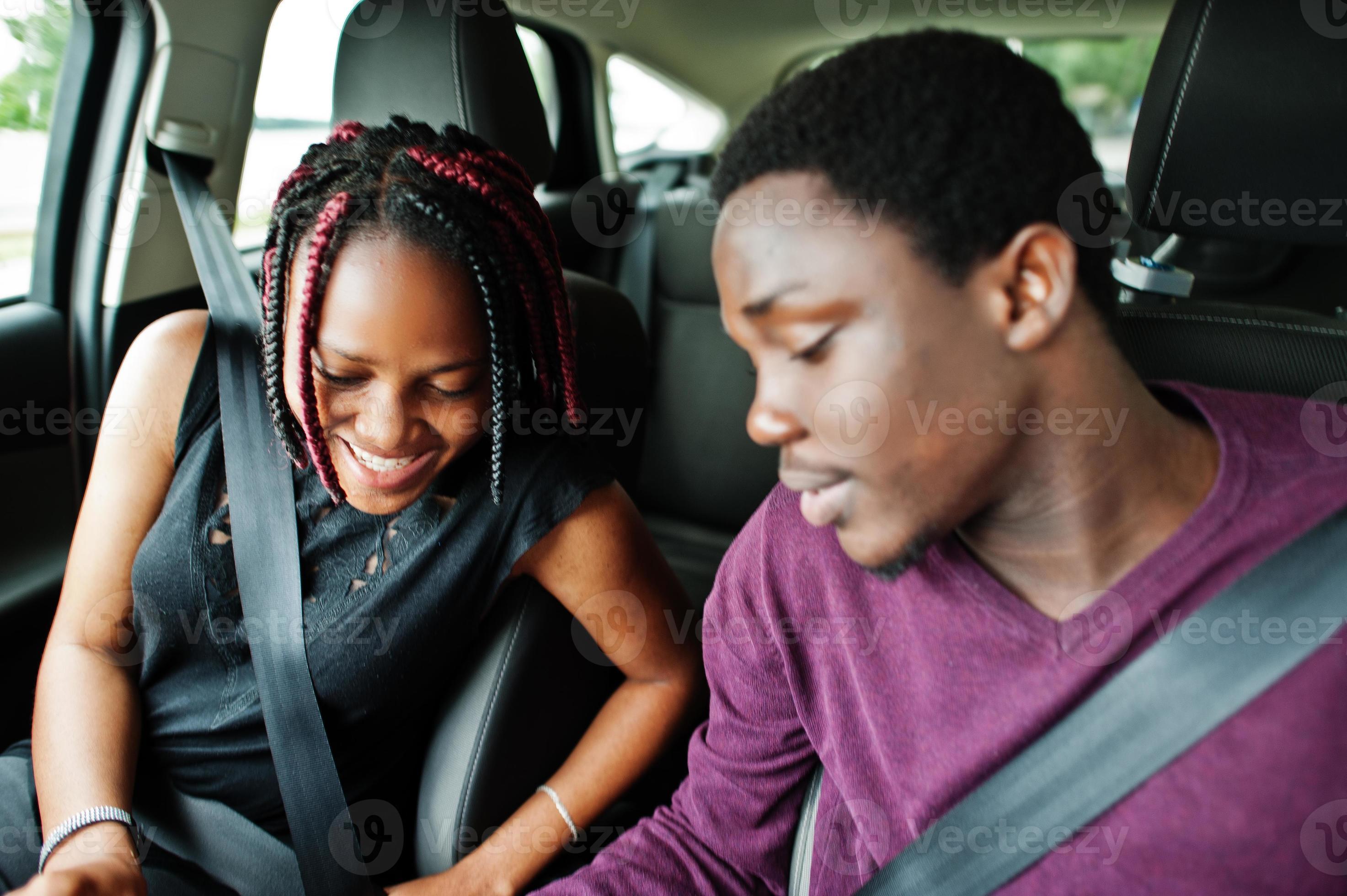 Beautiful young african american couple sitting on the front passenger seats while handsome man ...