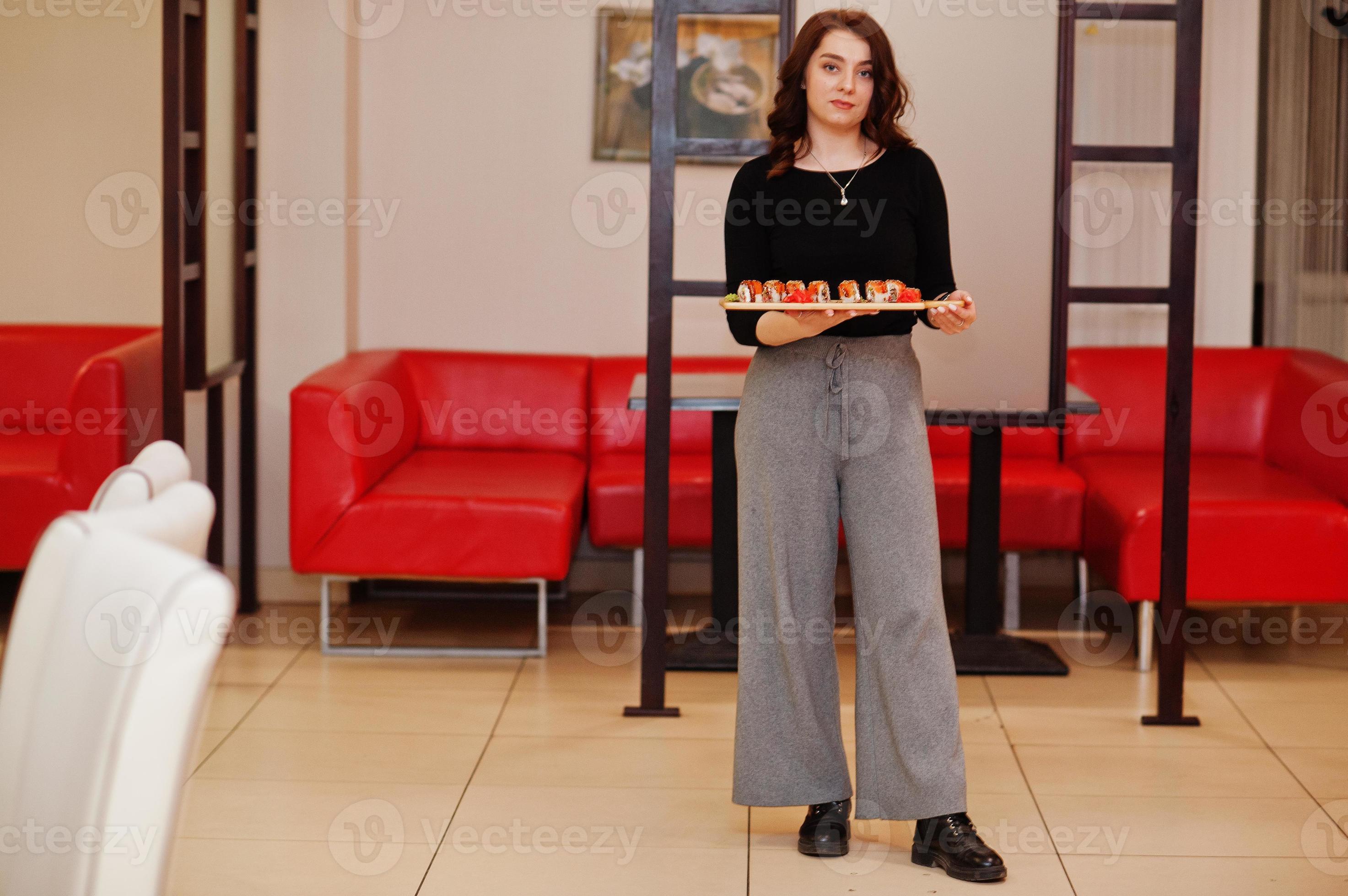 A Young Beautiful Girl Eating Sushi On Traditional Japanese Restaurant
