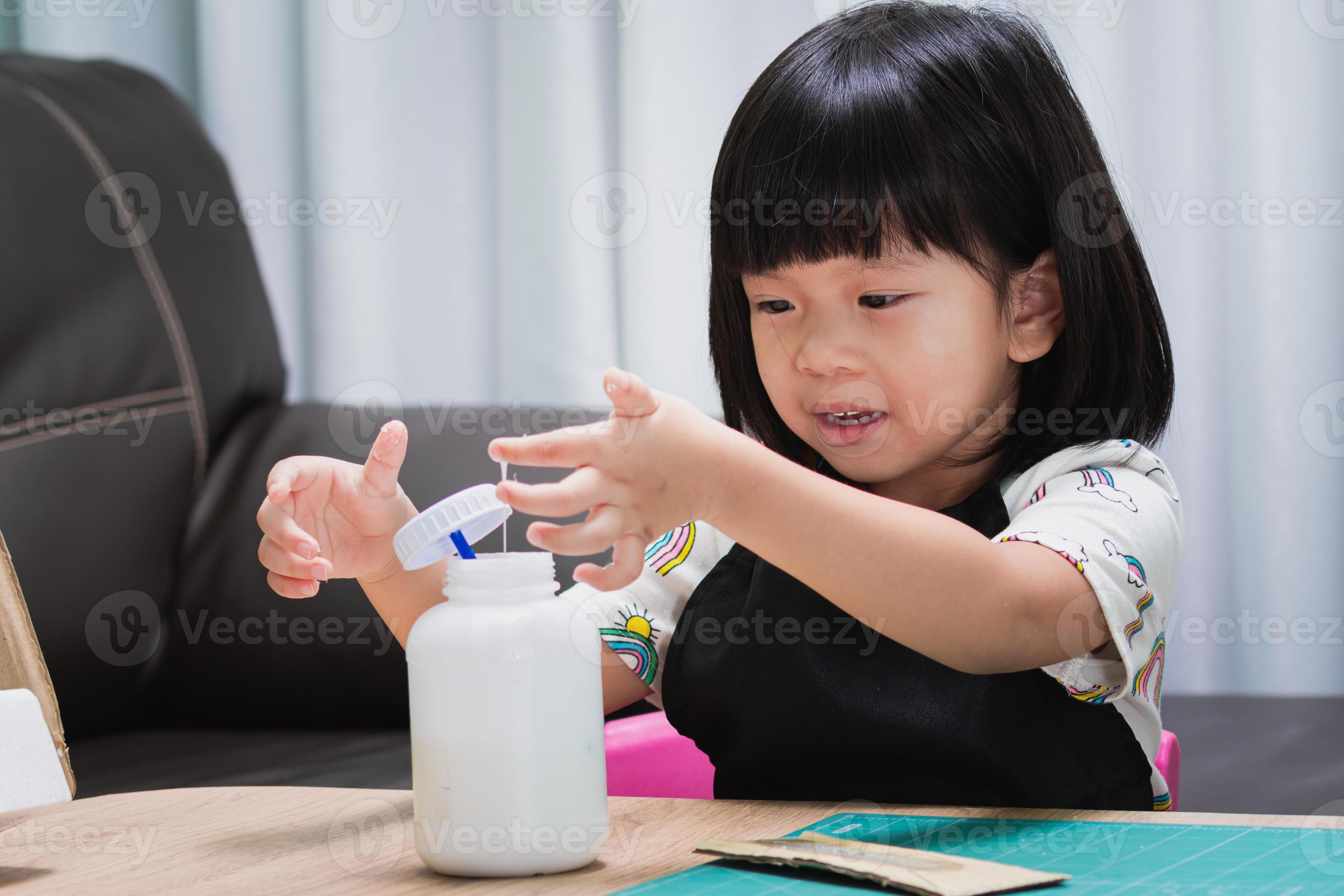 los niños de 4 a 5 años se divierten con pegamento blanco con las manos. los niños sonríen ...