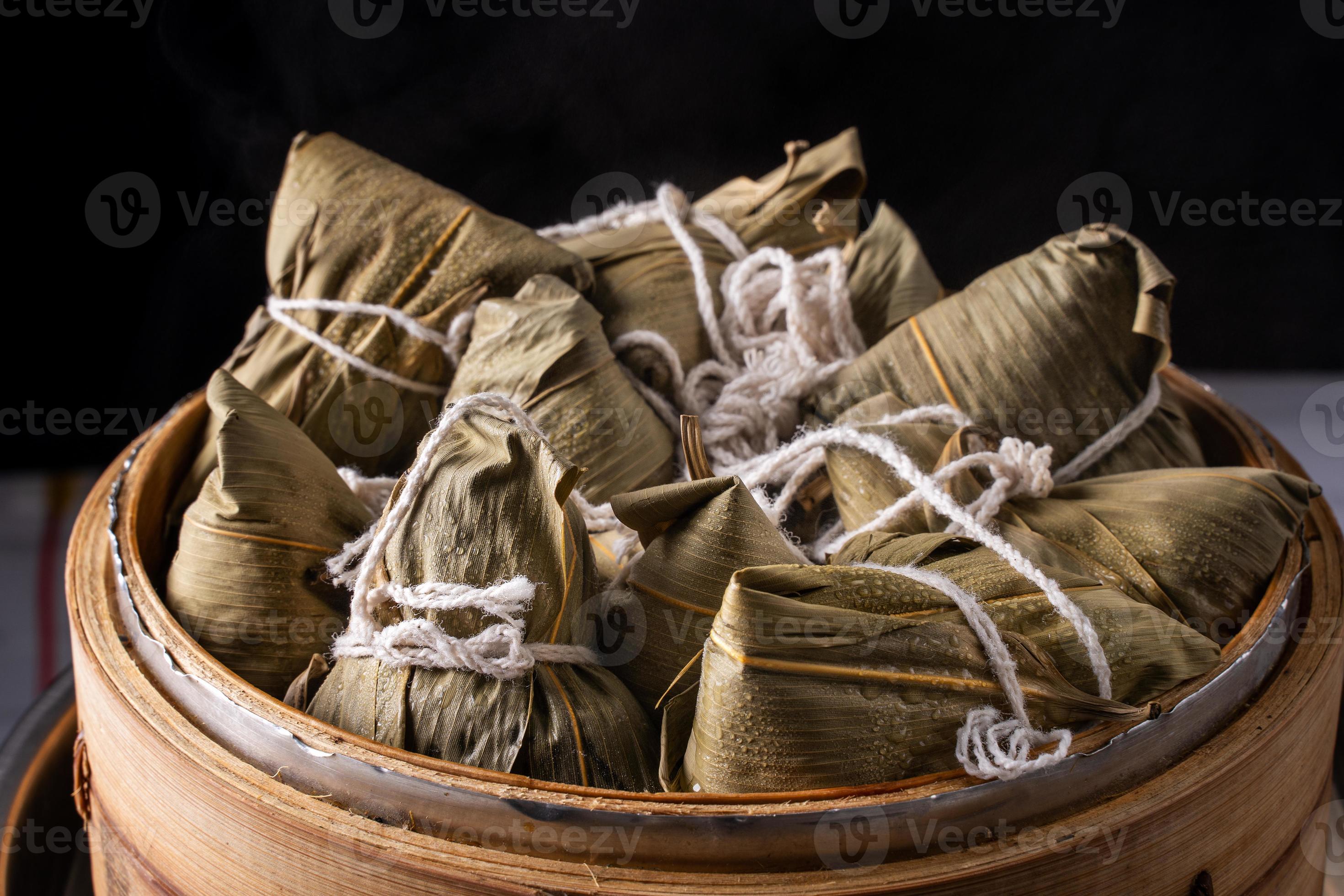 Rice dumpling, zongzi - Bunch of Chinese traditional cooked food on wooden table over black ...