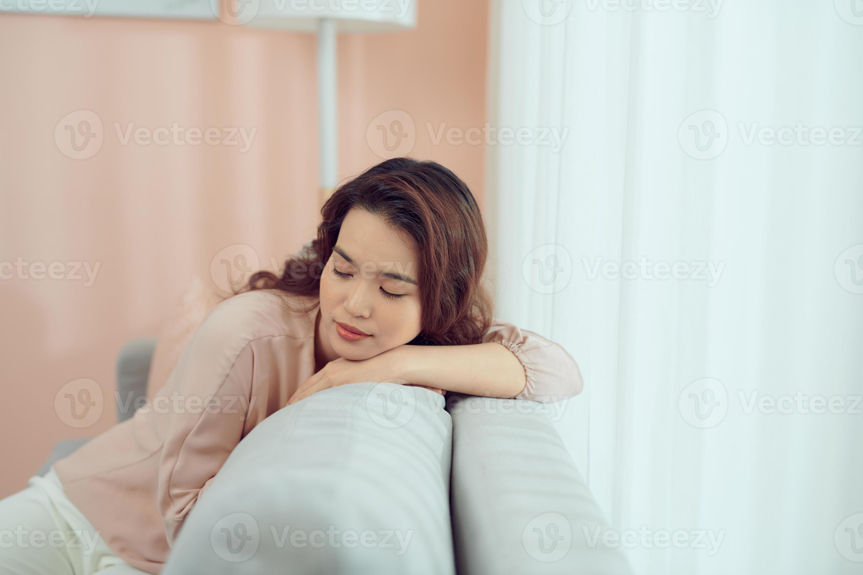 Tired attractive woman taking a nap on a sofa, close up of her face ...