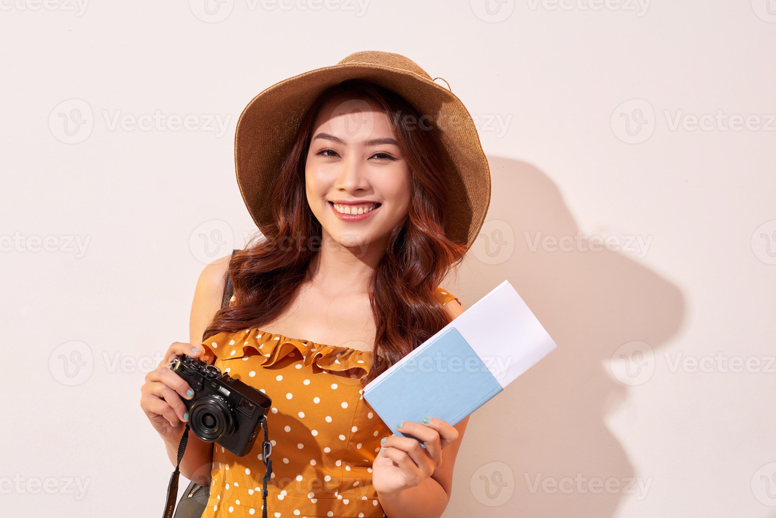 Portrait Of A Happy Young Woman In Hat Holding Camera And Showing Passport While Standing