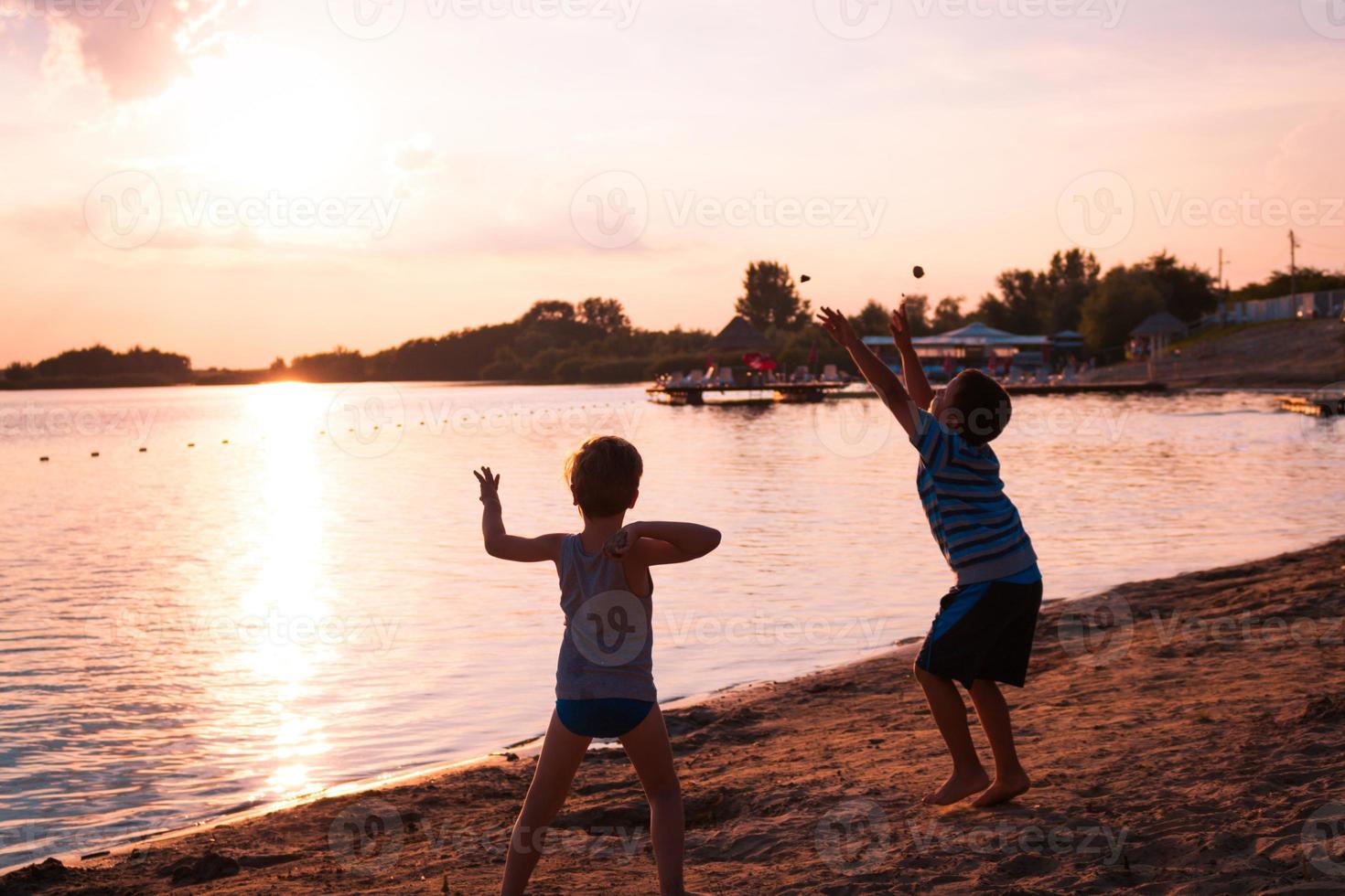 Two boys having fun on beach at sunset. 10909486 Stock Photo at Vecteezy