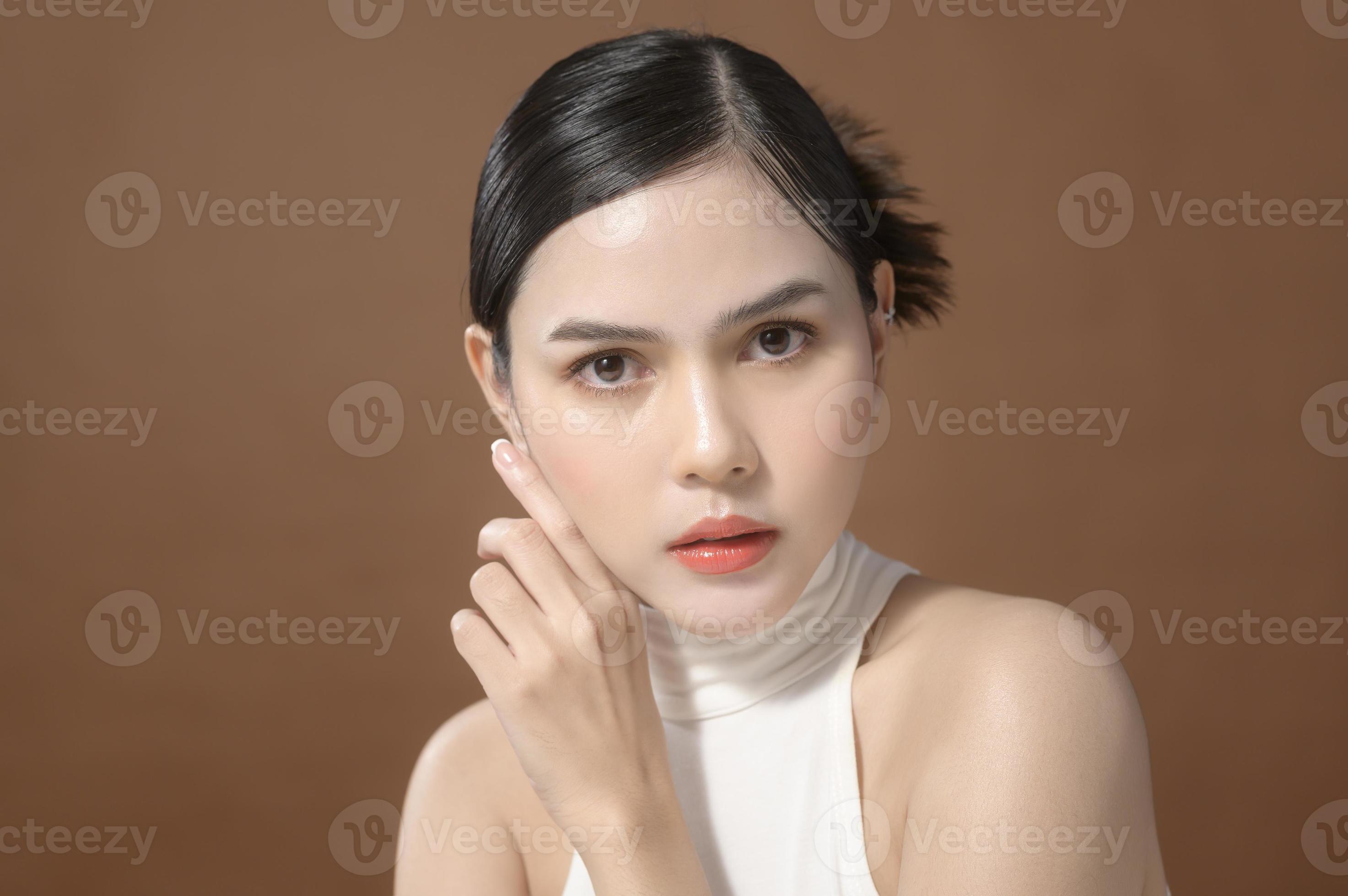 A Young Woman With Beautiful Face Smiling Touching Her Face Over