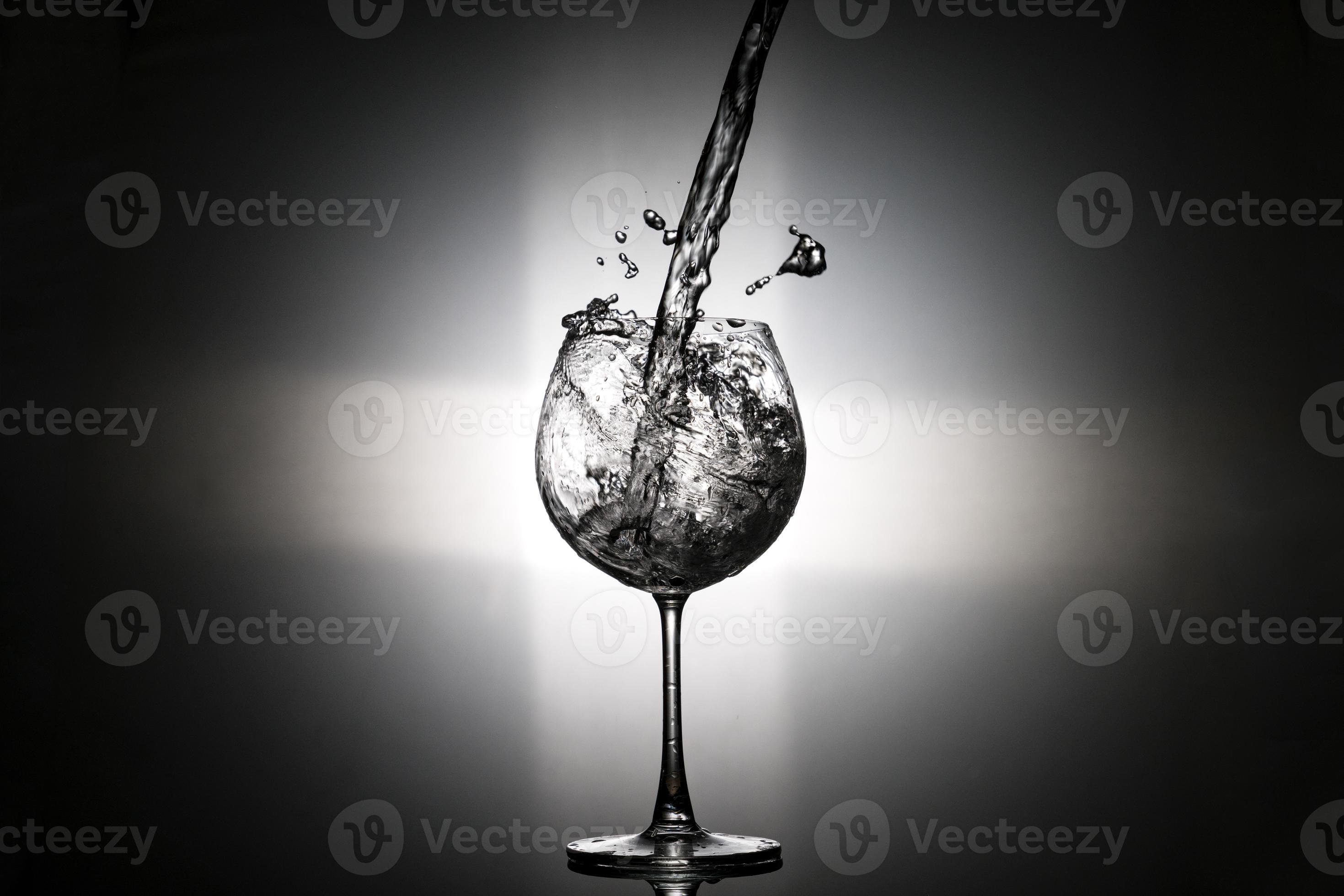 Pouring water in to the wine glass with rear light on black background 11084835 Stock Photo at ...