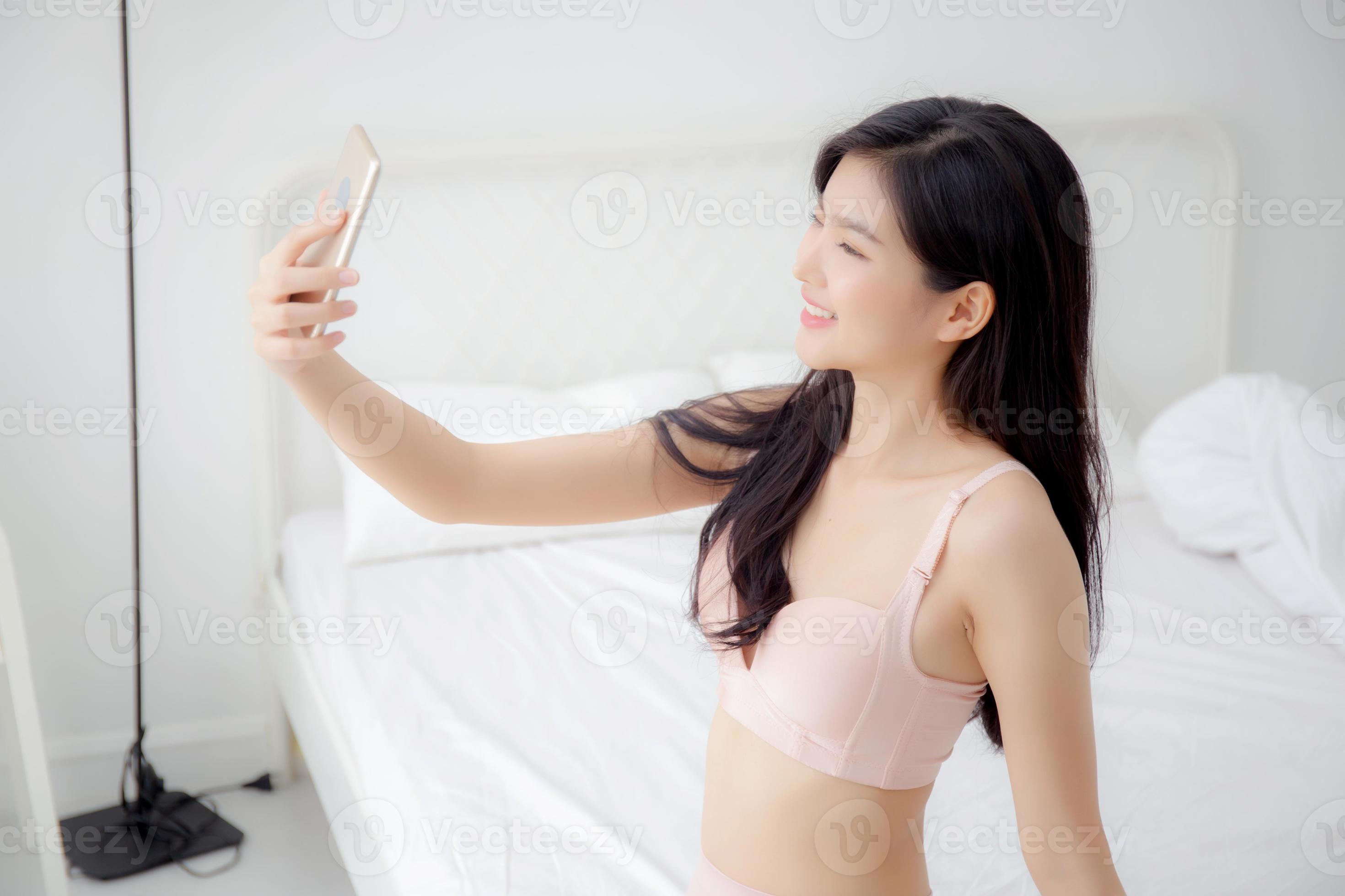 Beautiful young asian woman sexy in underwear talking a selfie on smartphone for social network ...