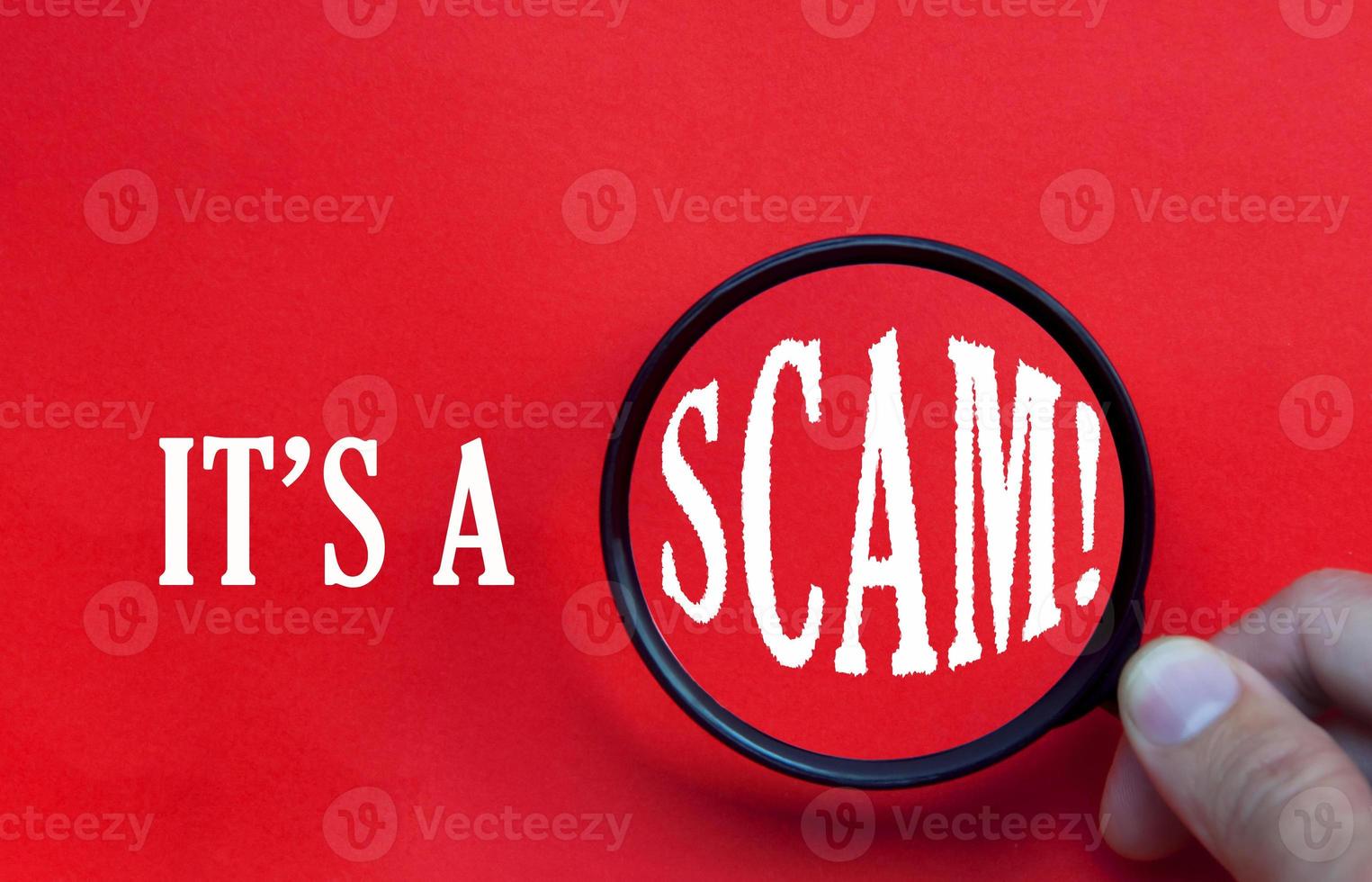 It's a scam text on red cover with hand holding magnifying glass ... It's a scam text on red cover with hand holding magnifying glass ...