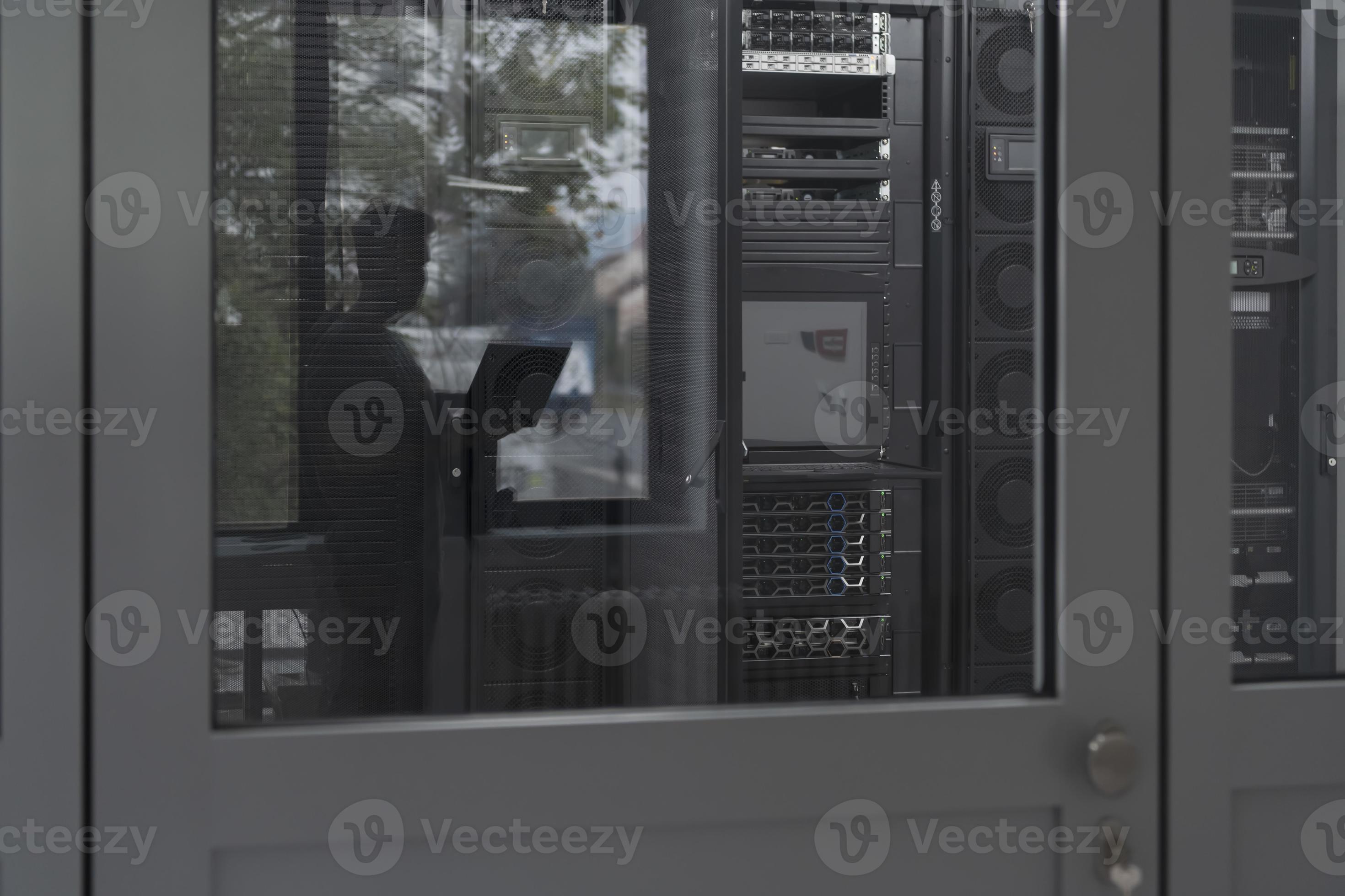 Software Engineer Working On A Laptop Computer In A Modern Server Room