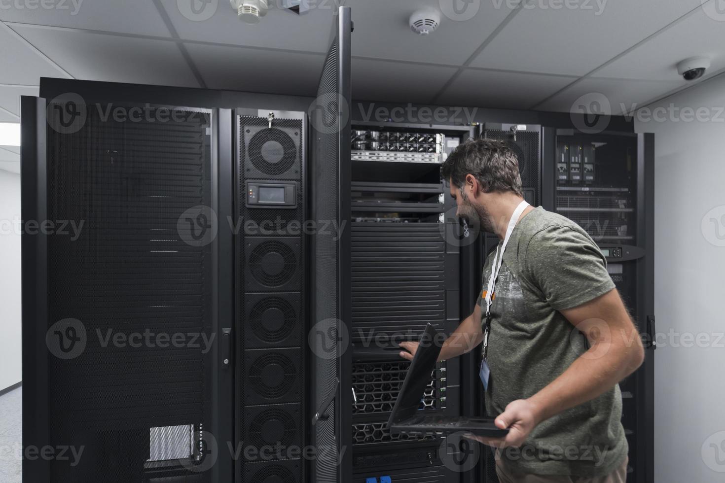 Data Center Engineer Usaing Keyboard On A Supercomputer Server Room