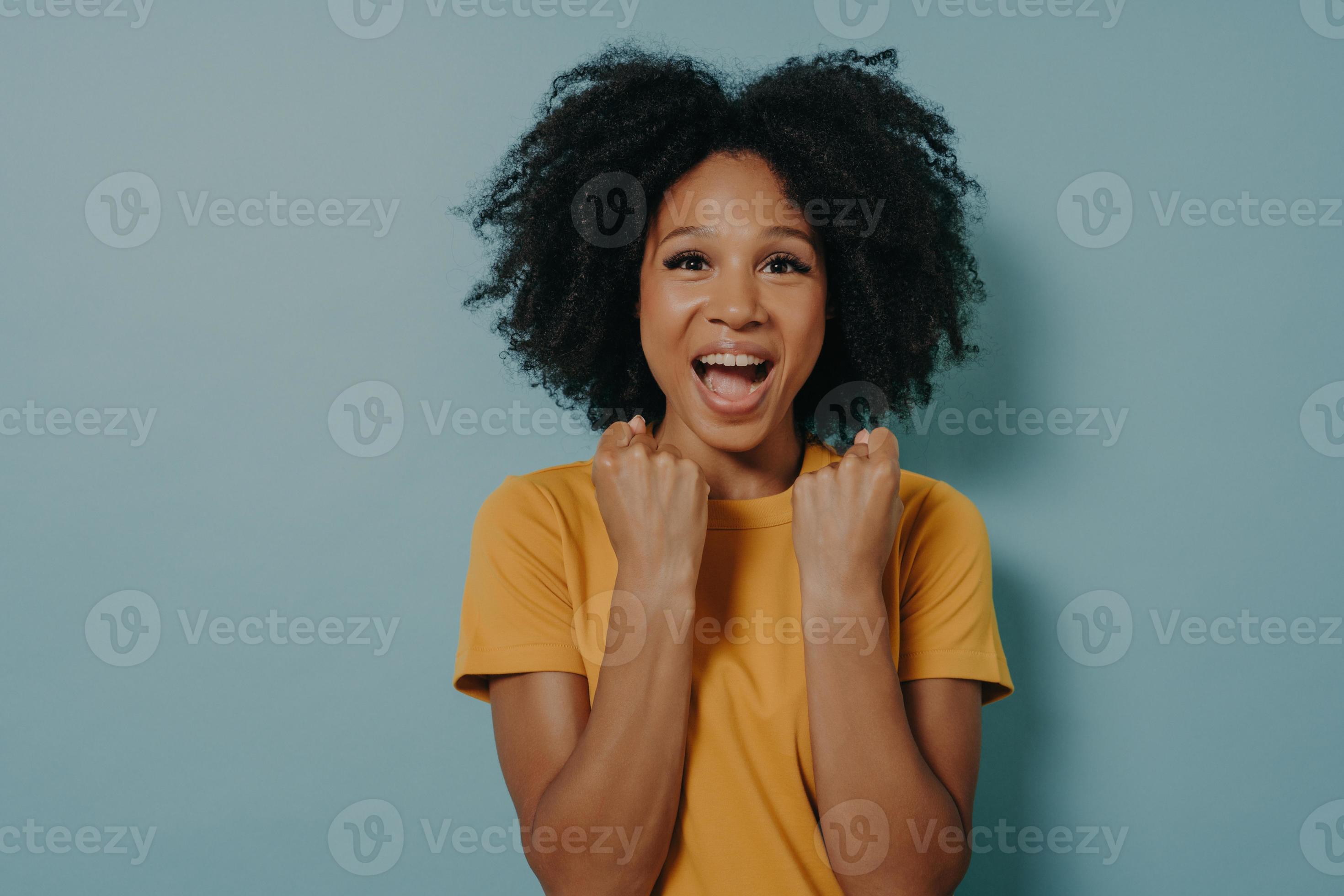 Happy Dark Skinned Woman Enjoys Wonderful Life Clenches Fists With Joy
