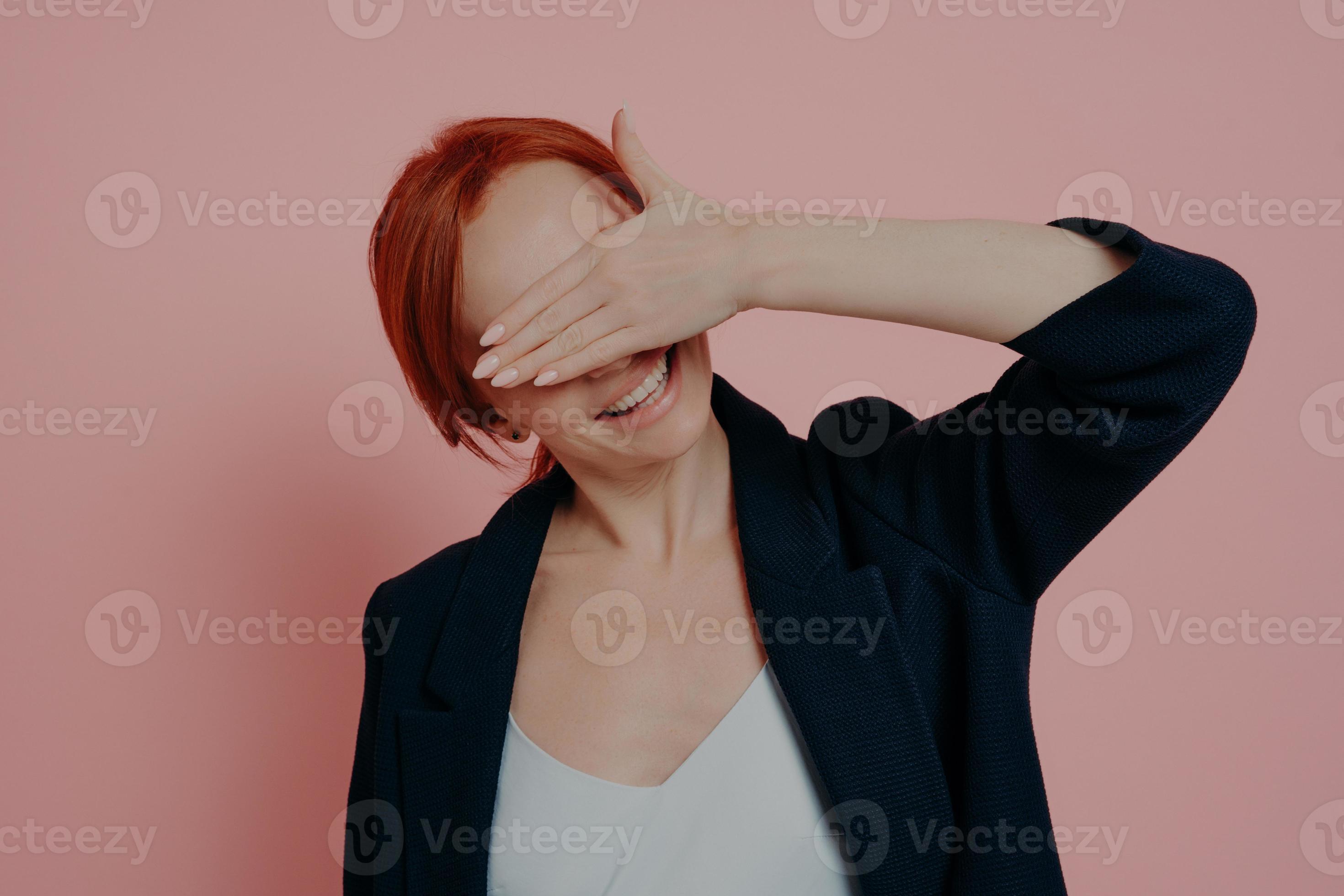 Cute Positive Ginger Woman Holding Hand In Front Of Face Covering Eyes In Anticipation For