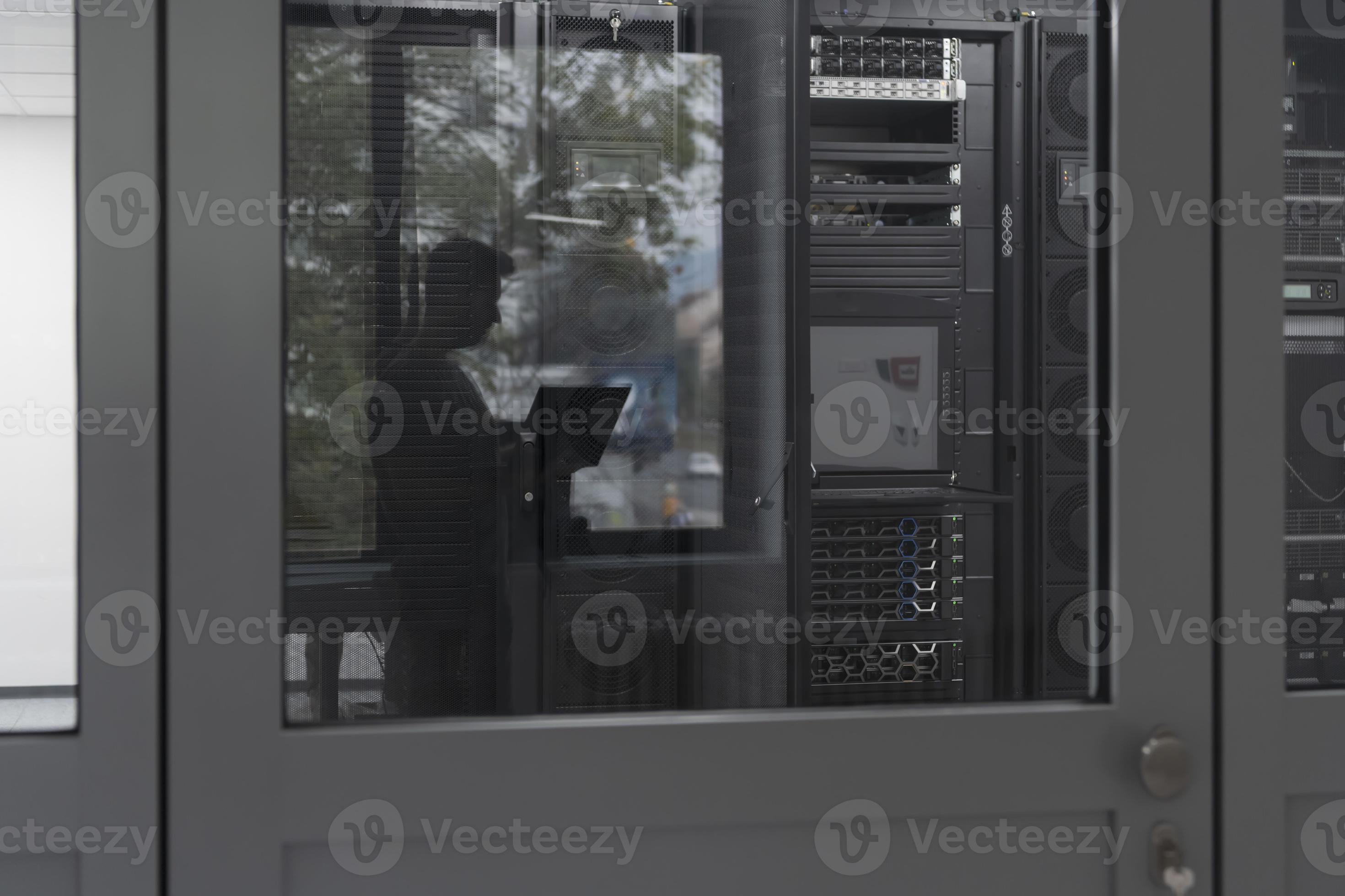 Software Engineer Working On A Laptop Computer In A Modern Server Room