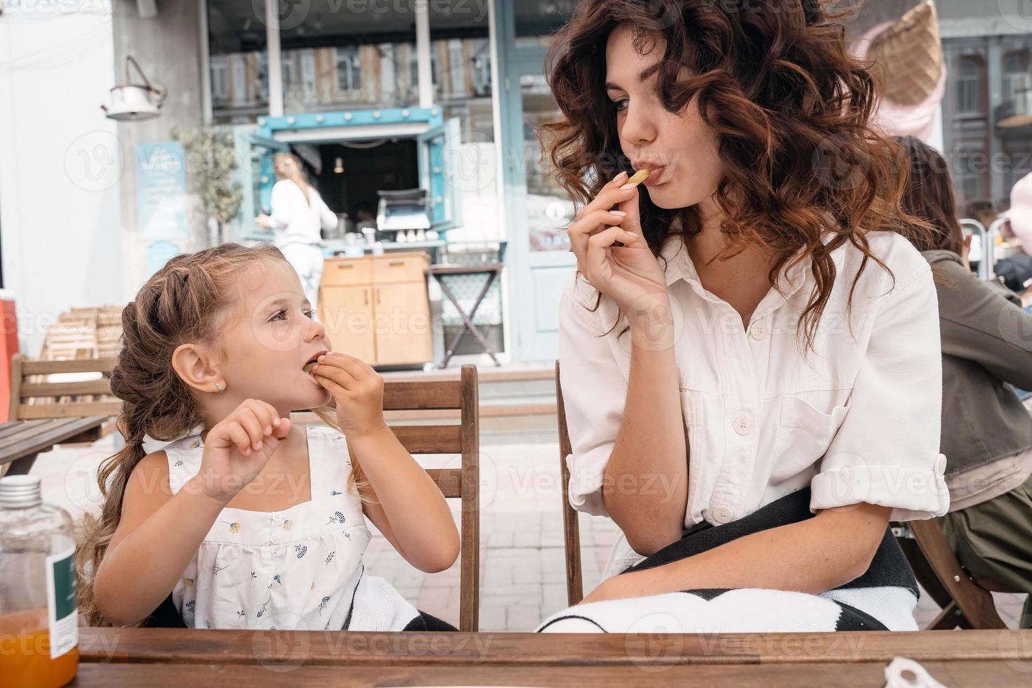 Mamá E Hija Comen Papas Fritas En Un Café Al Aire Libre 11439293 Foto De Stock En Vecteezy