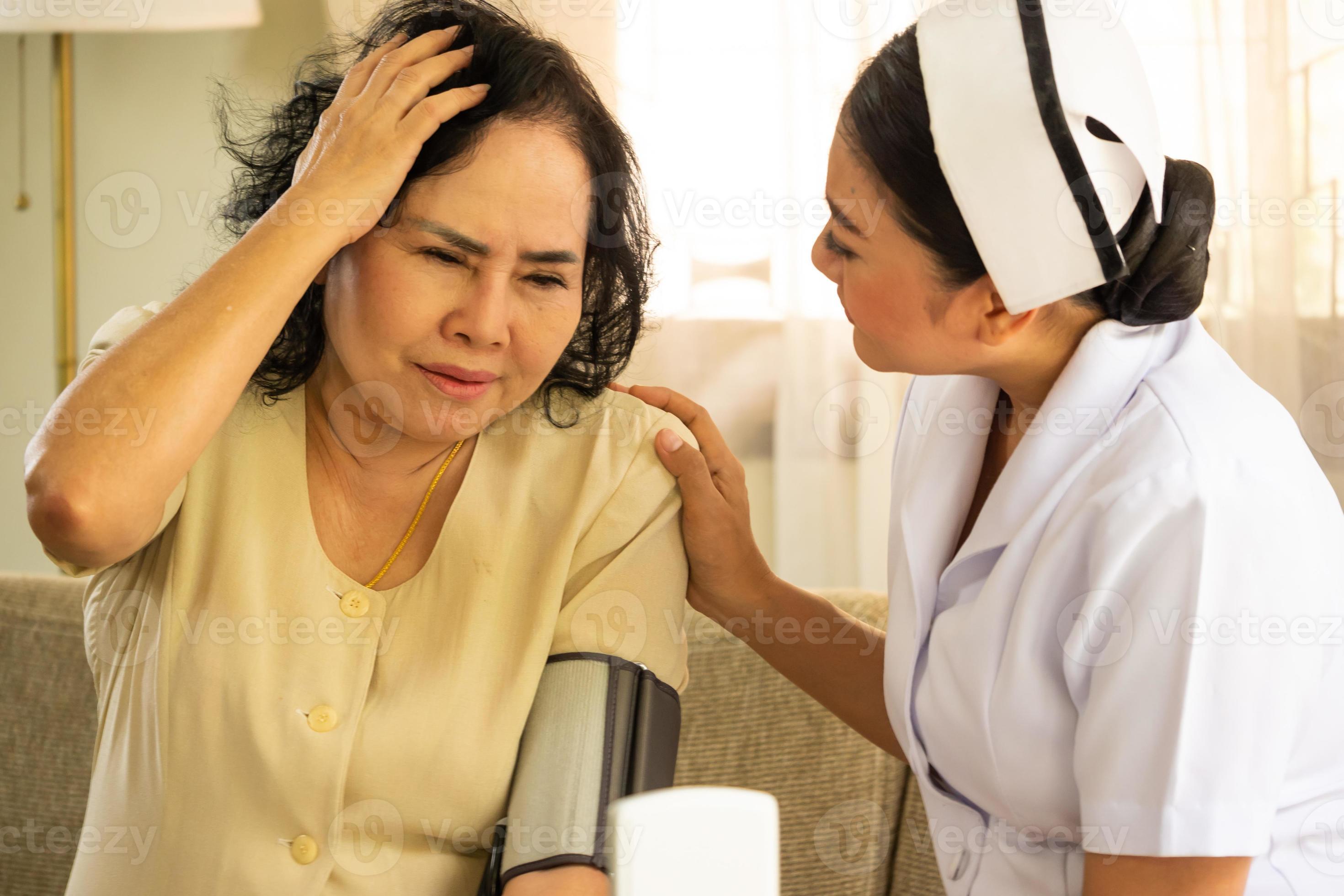Asian nurse doing pressure measuring for female patient who hasing headache in the room ...