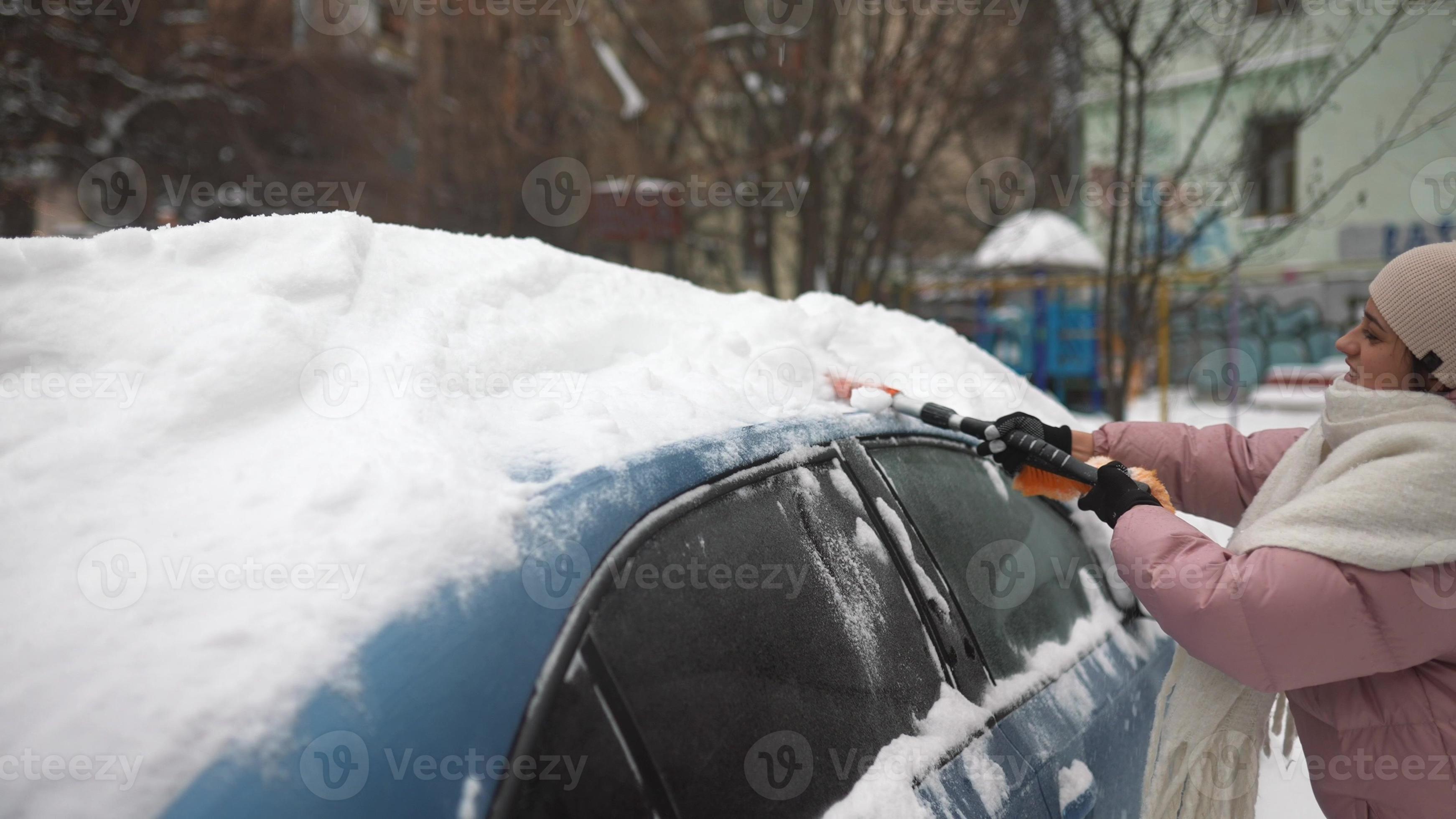 Woman removing snow from car 11763716 Stock Photo at Vecteezy