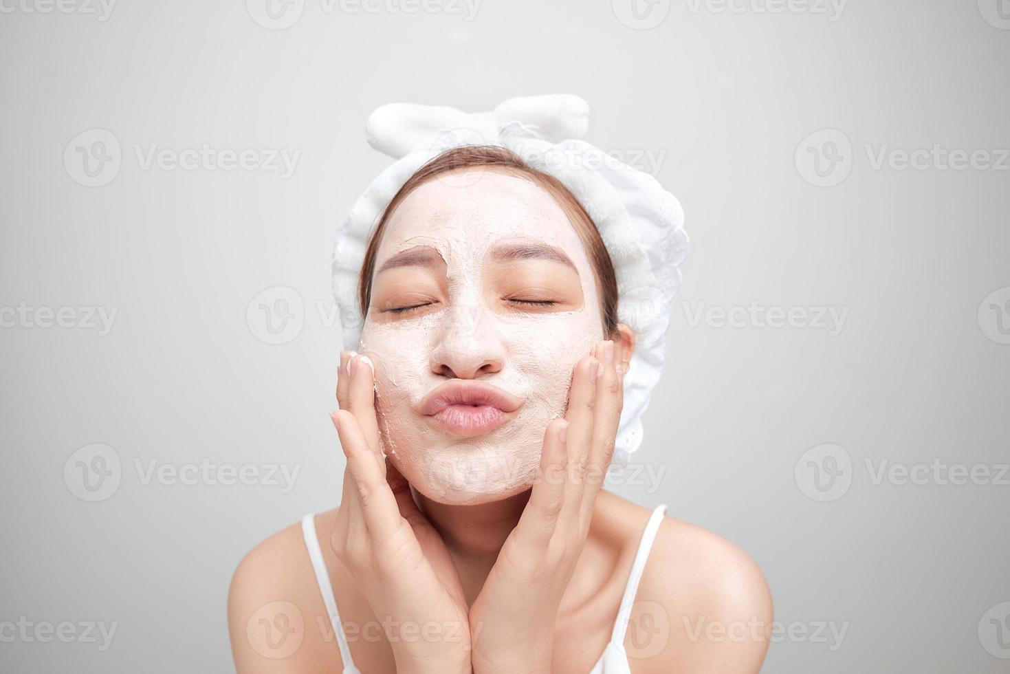 Young Asian Woman Applying Facial Clay Mask Over White Background Beauty Treatments Concept