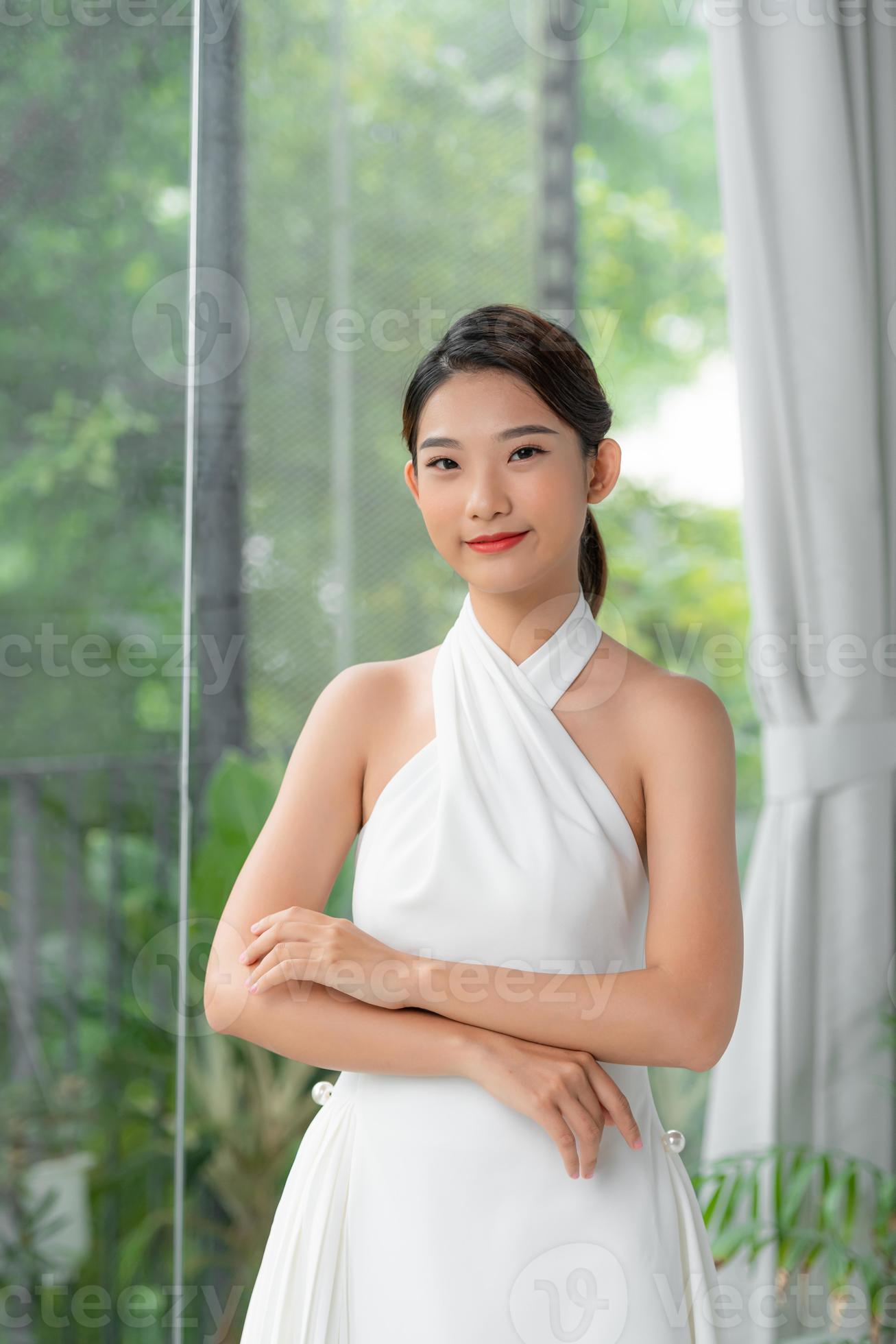 Portrait of young beautiful business woman in the office. Crossed arms ...