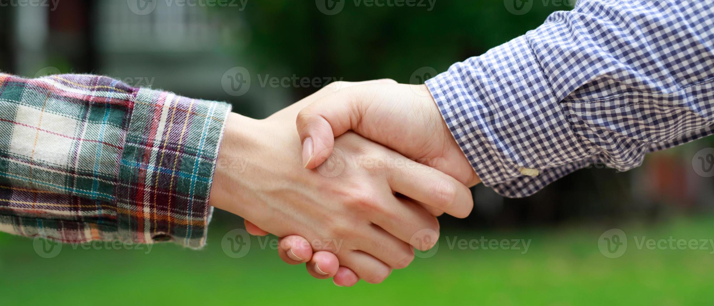 Closeup of a business hand shake between two colleagues Plaid shirt ... Closeup of a business hand shake between two colleagues Plaid shirt ...