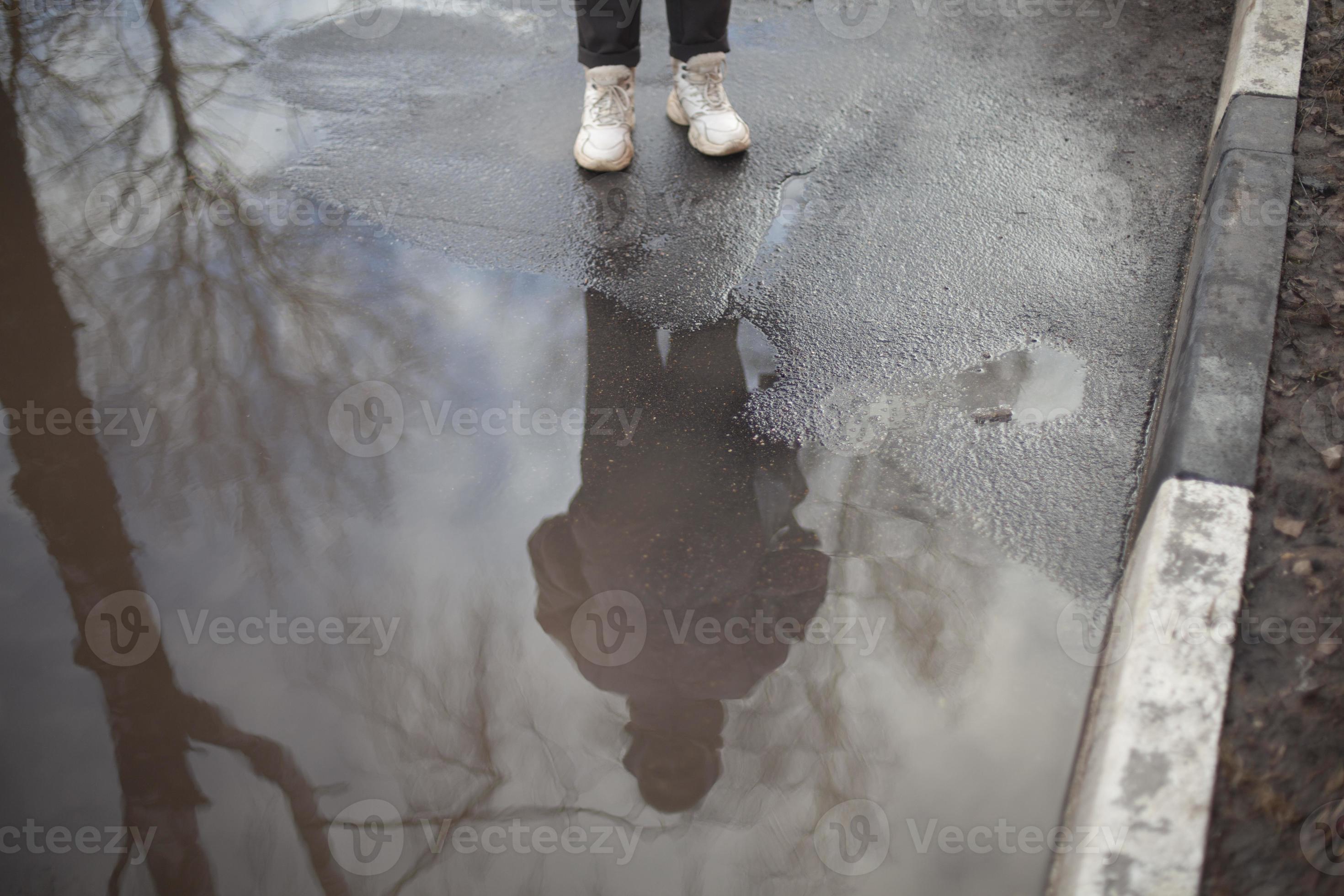 Reflection of person in puddle. Puddle outside. Person stands on wet road. 11943687 Stock Photo ...