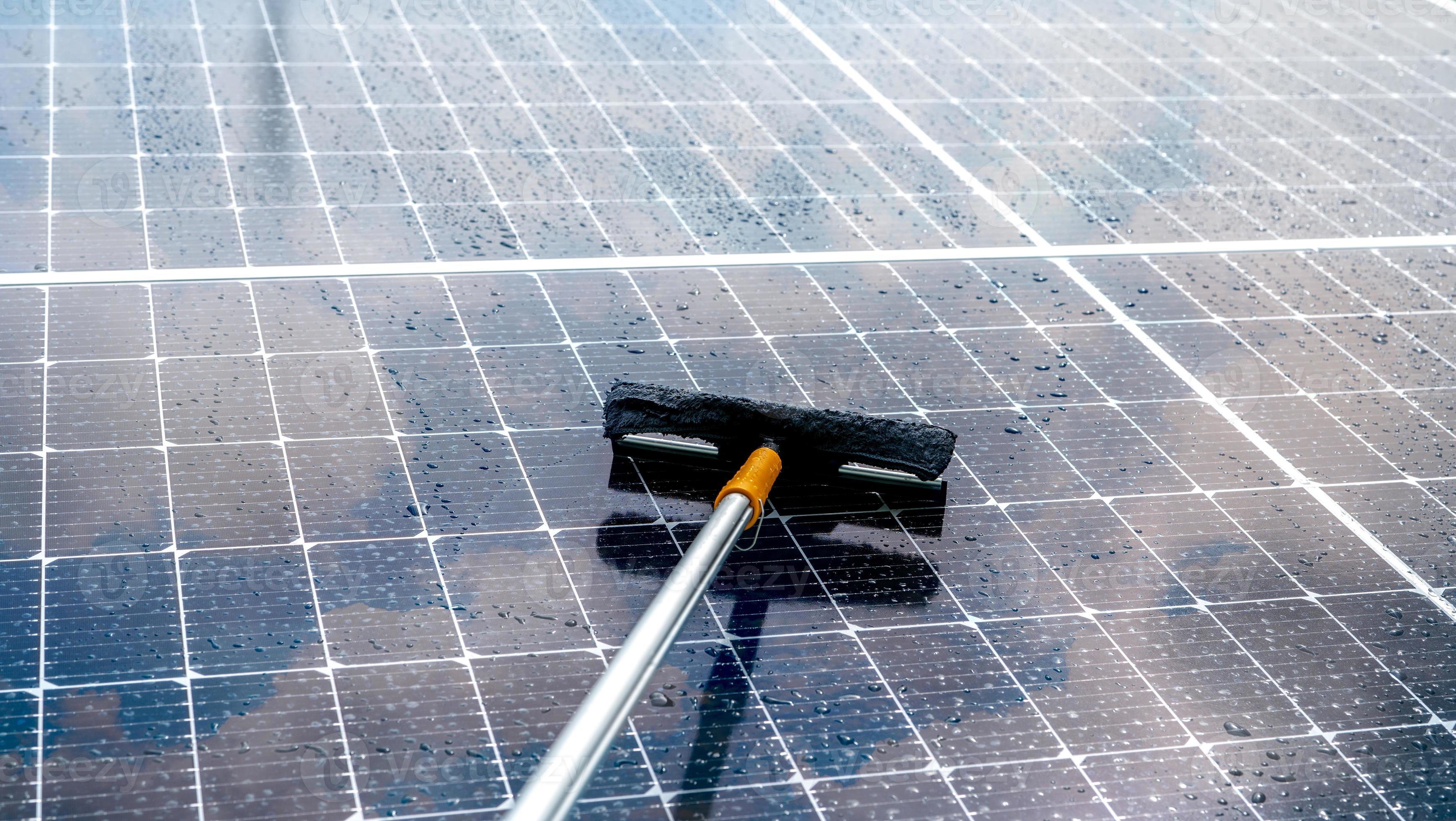 Cleaning solar panel with microfiber mop on wet roof. Solar panel or ...