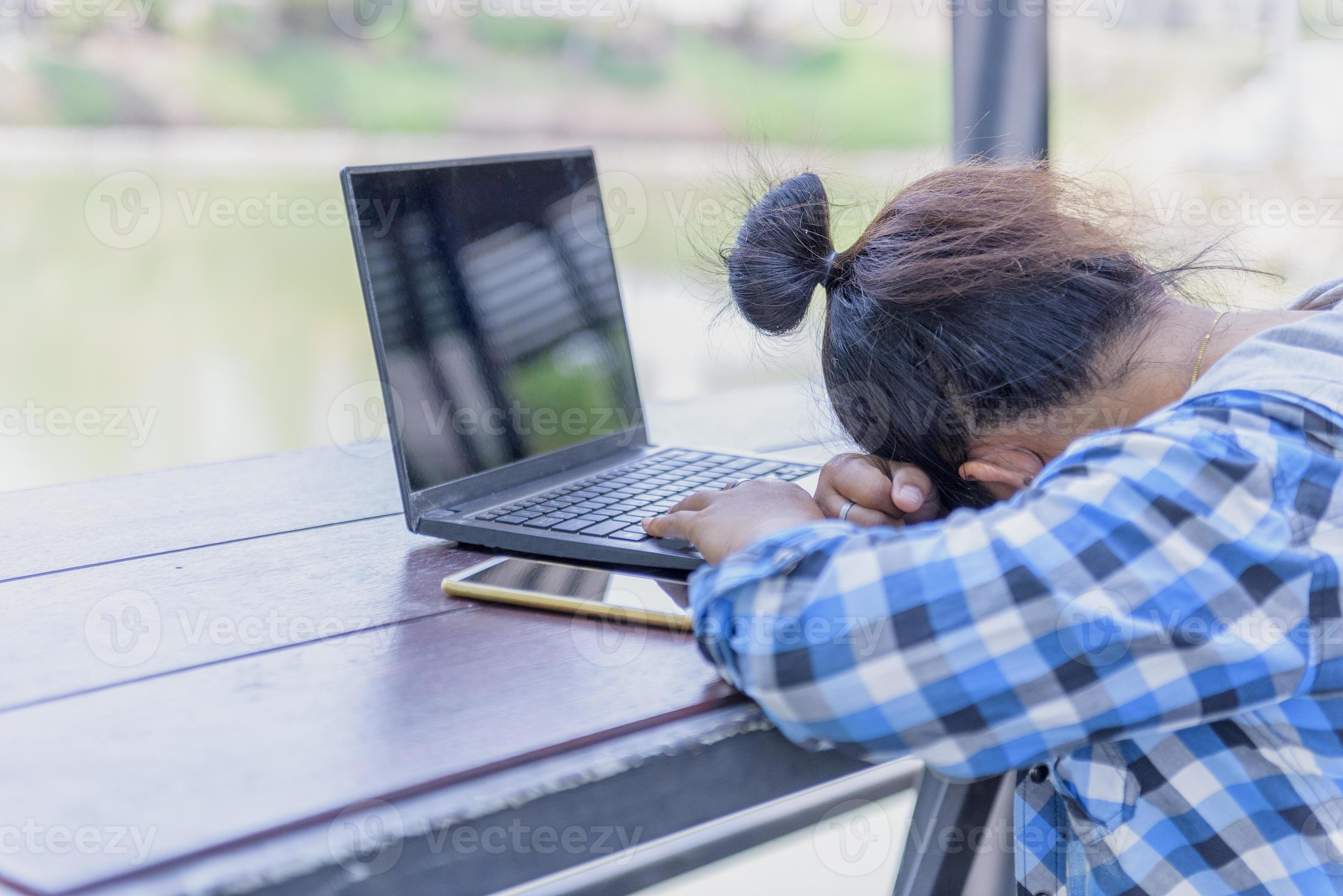 mujer de negocios joven con exceso de trabajo y cansada durmiendo en el escritorio en el trabajo ...