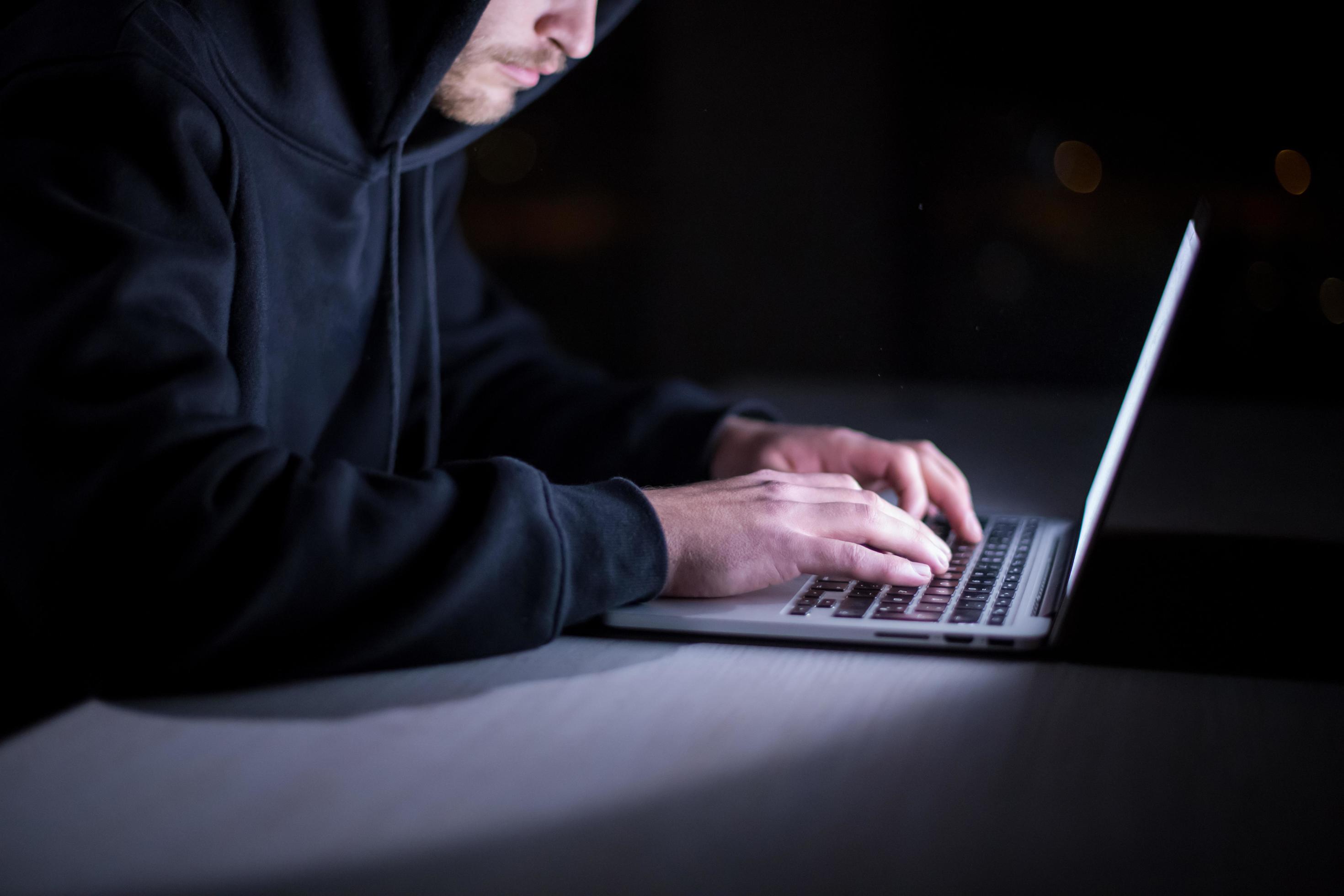 hacker using laptop computer while working in dark office 12417787 ...