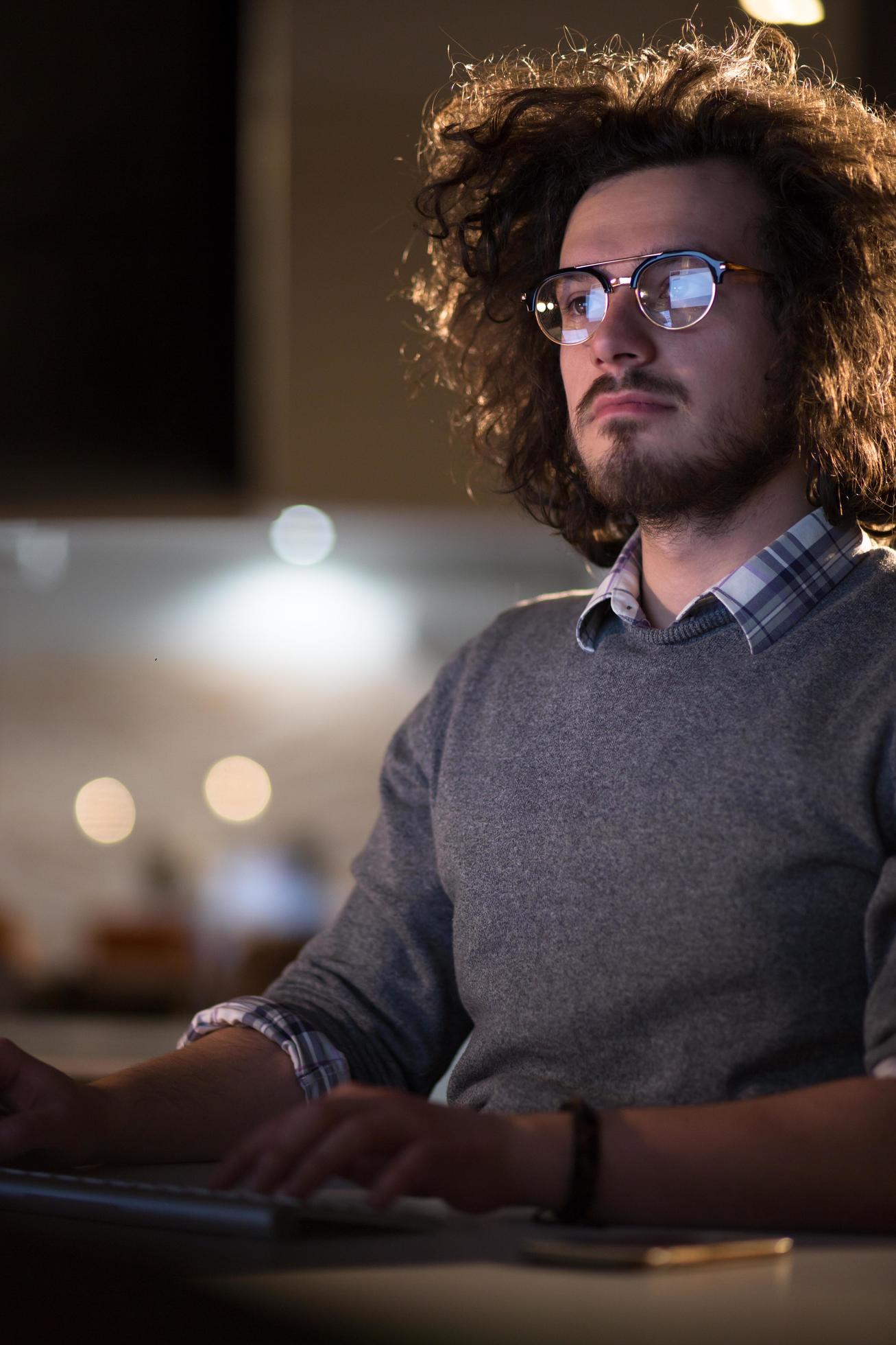man working on computer in dark office 12436311 Stock Photo at Vecteezy