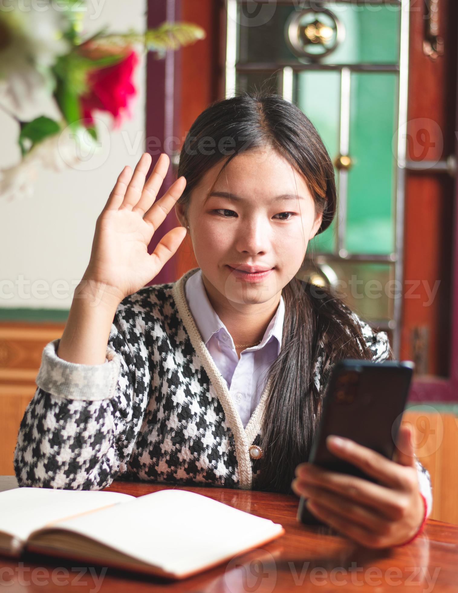 A young women student is video calling with teacher for online learning ...