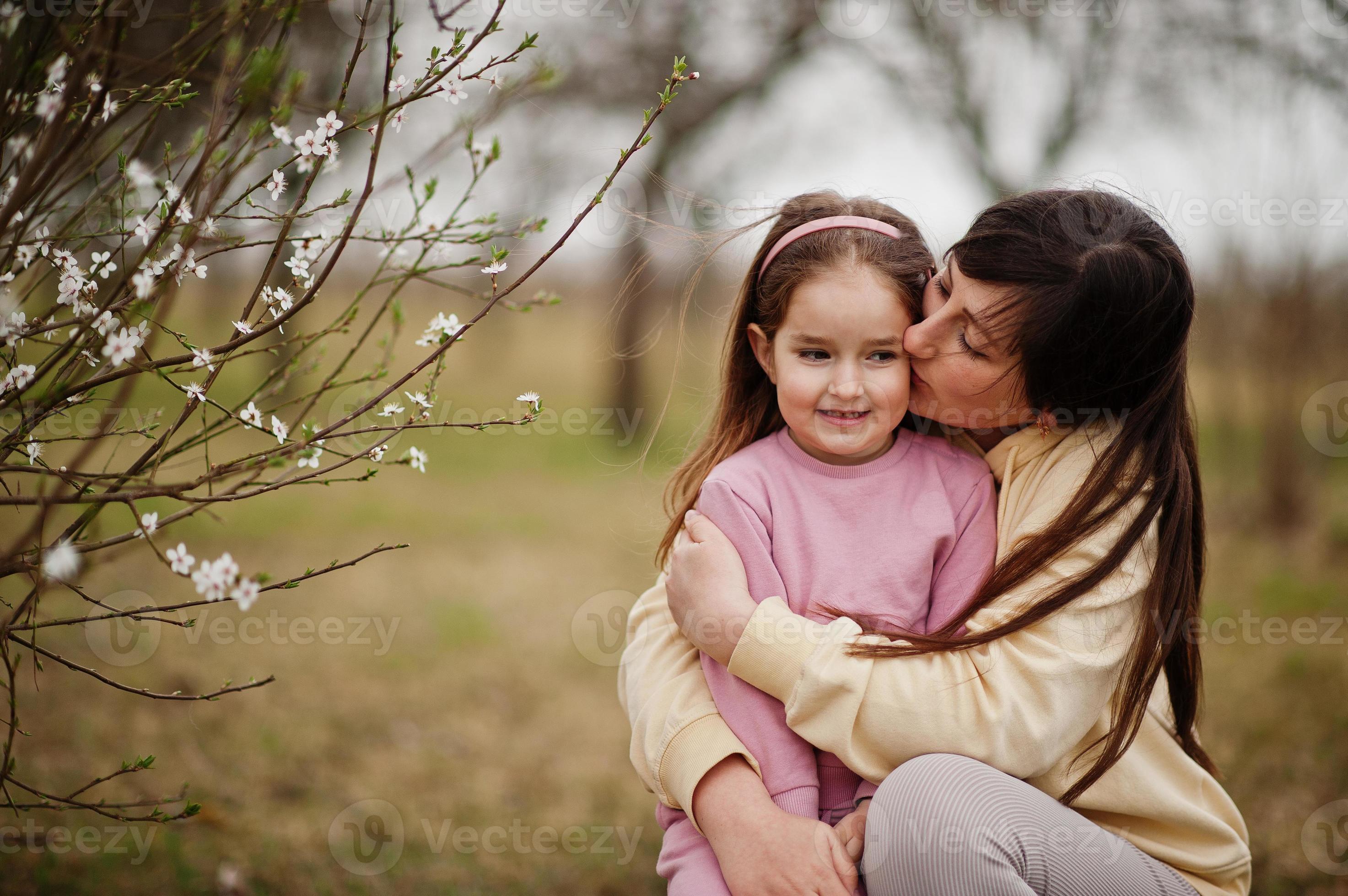 Mother hug her baby girl daughter in spring garden. 12521718 Stock Photo at Vecteezy