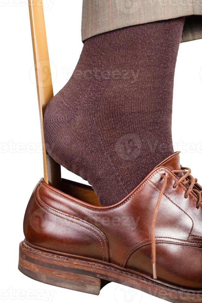 man dons brown shoe with shoehorn isolated 12570618 Stock Photo at Vecteezy