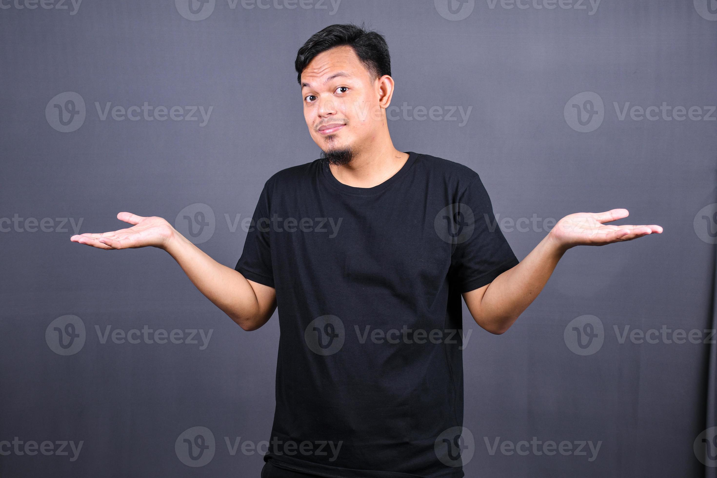Closeup portrait asian young man shrugging shoulders. I don't know ...