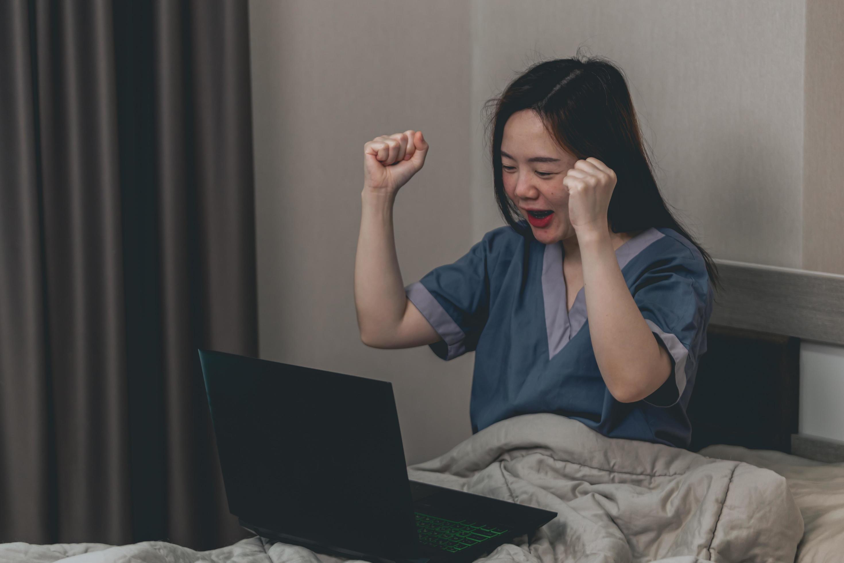 emocionada mujer asiática sintiéndose eufórica celebrando el resultado del éxito de la victoria ...