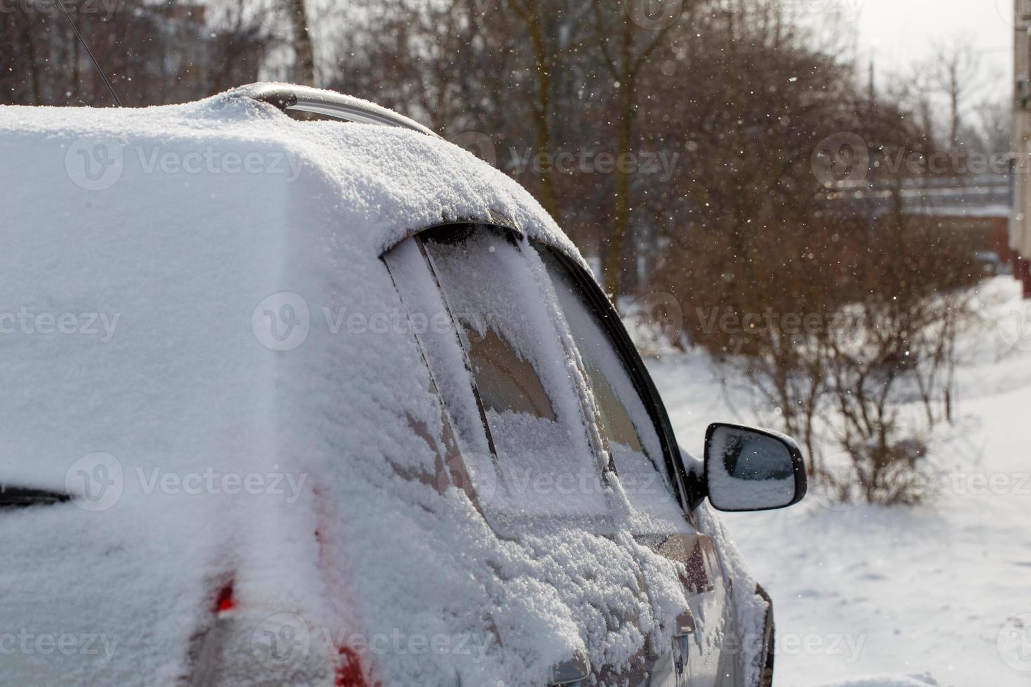close-up view of car covered with snow and snow drift on its wheel ...